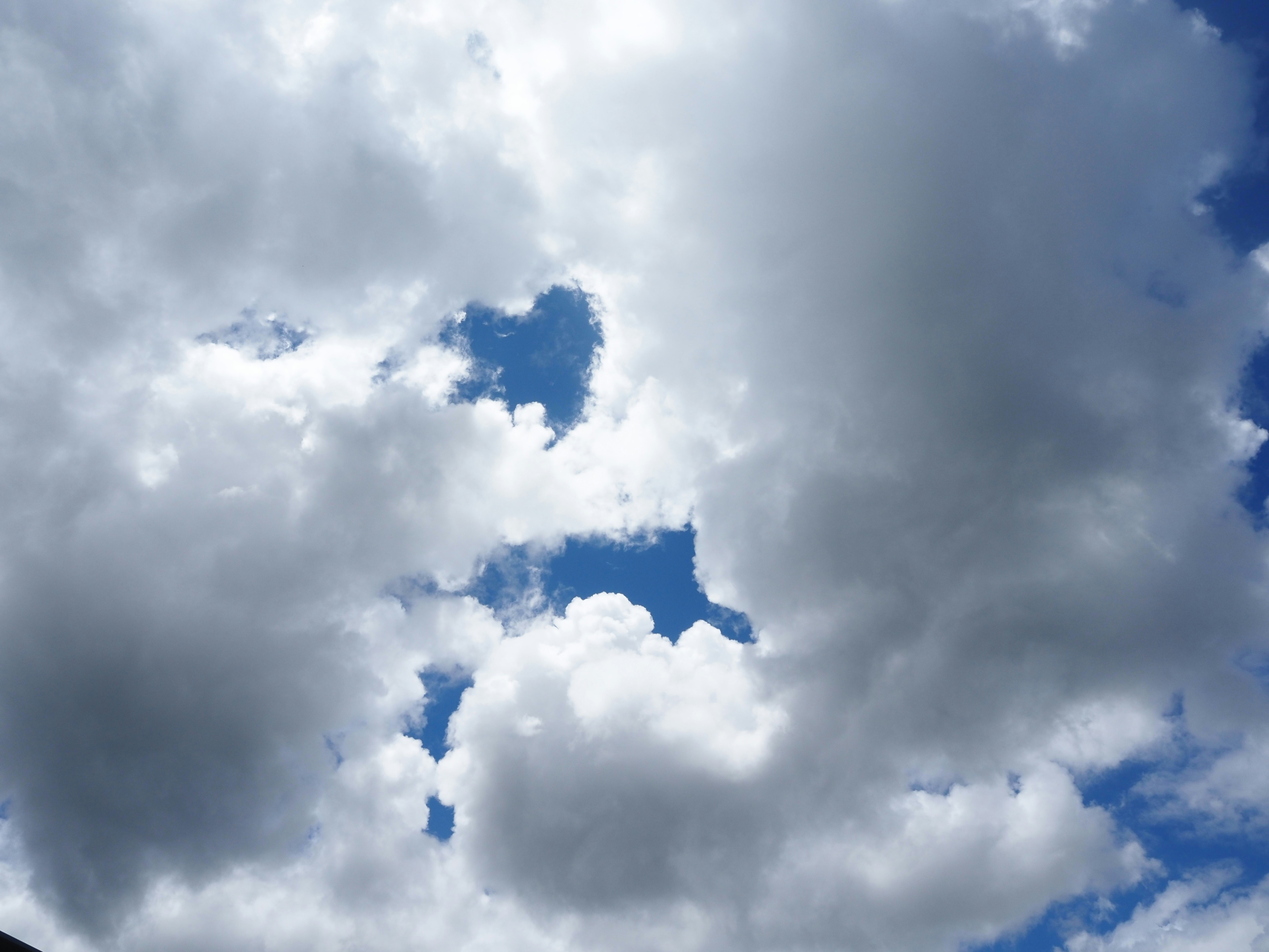 Cloudscape Breakthrough: Patch of Blue Sky Amid Whirl of Clouds