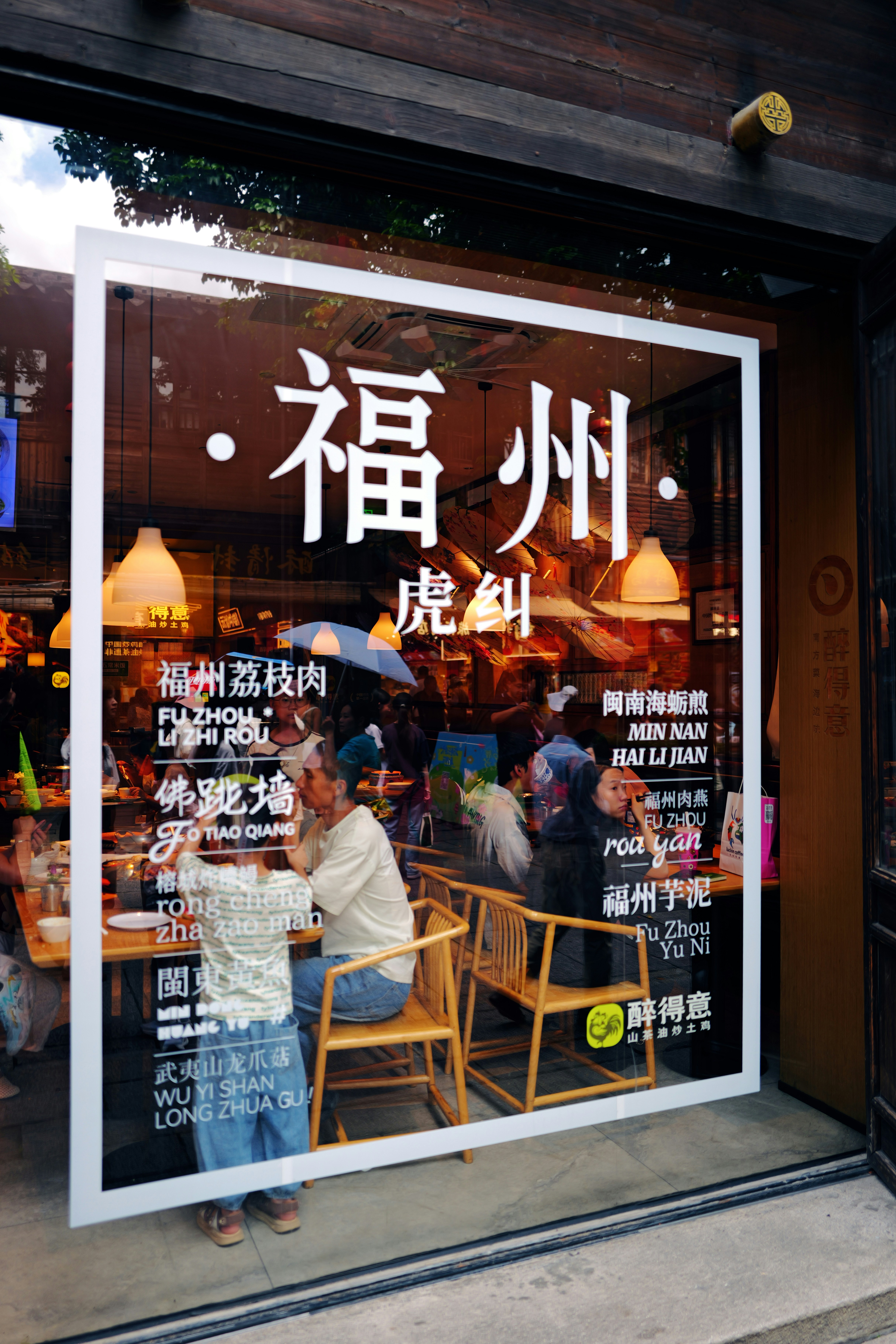 Glass-framed storefront with bold Chinese characters and warm interior glow