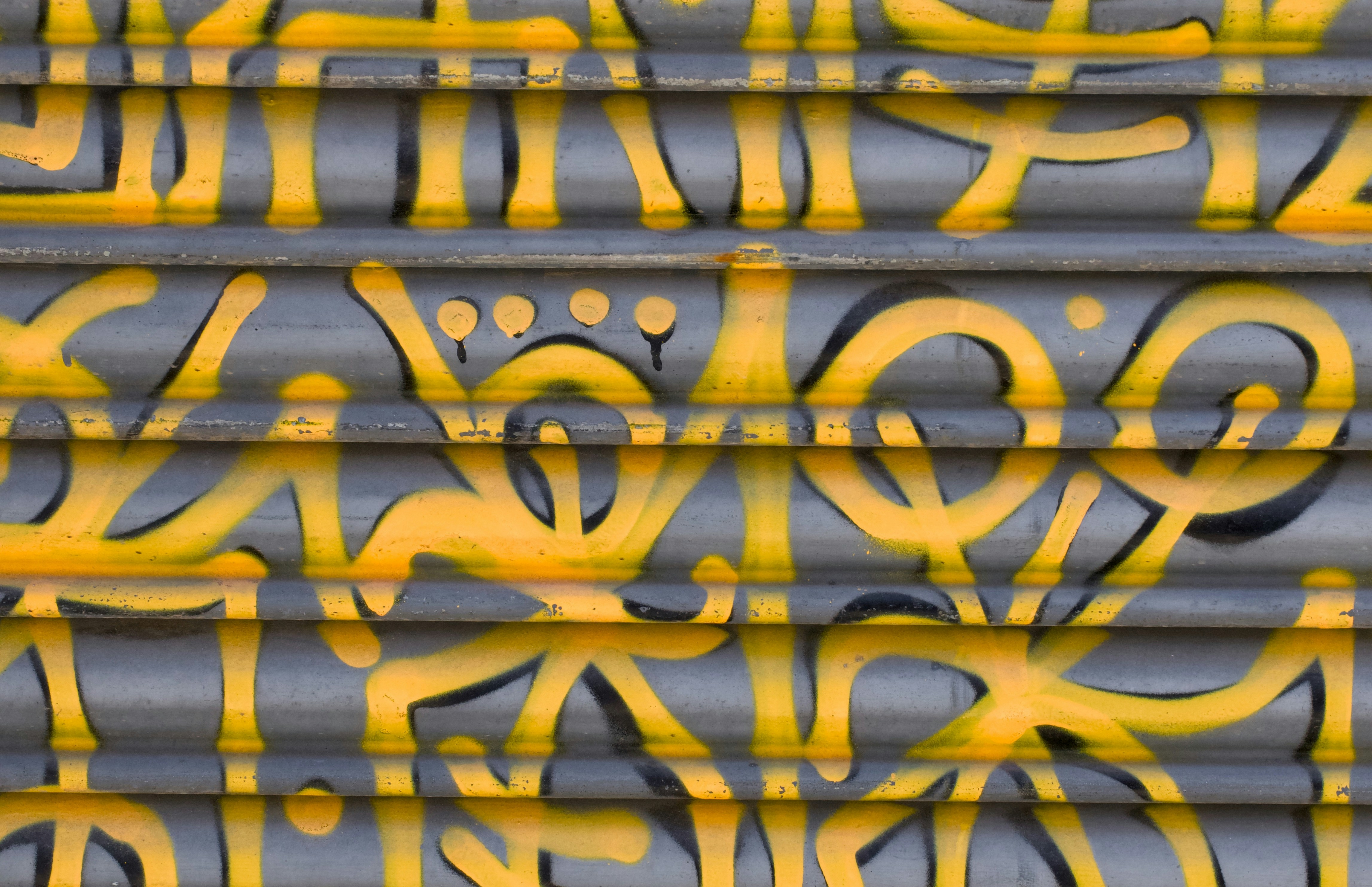 Yellow Tags on Slatted Metal: Urban Graffiti Pattern
