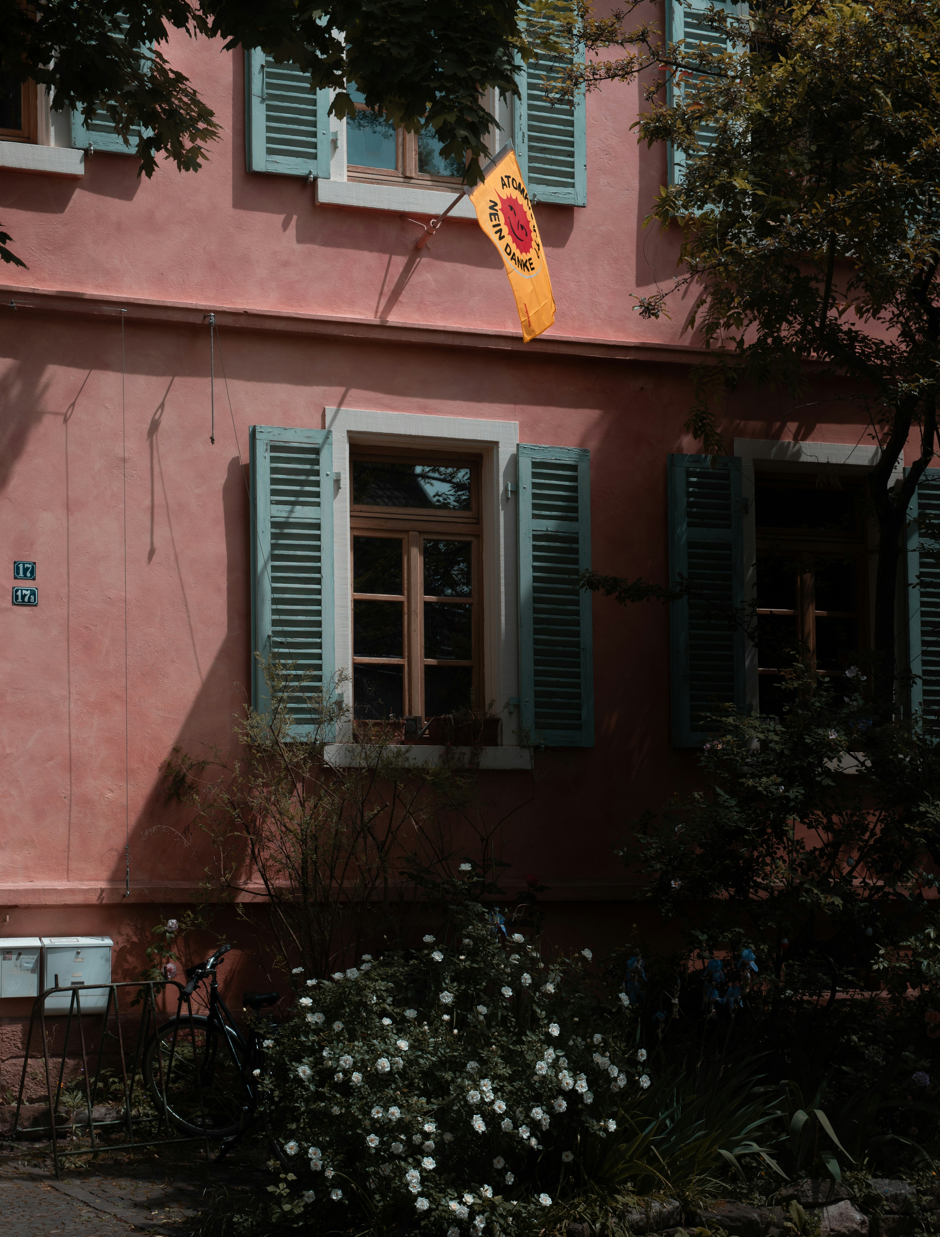 Pastel Facade with Open Shutters and a Distant Banner