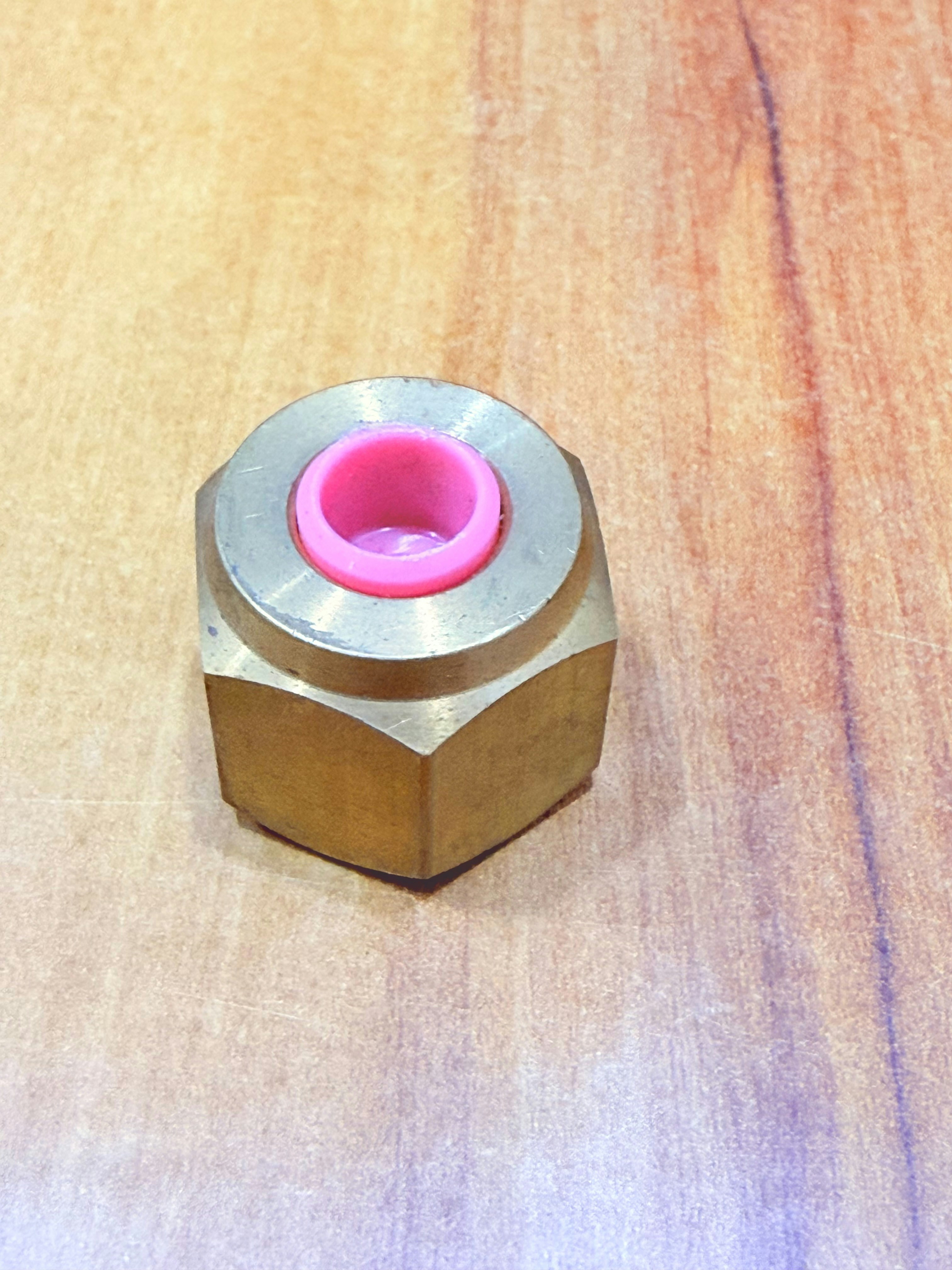 Precision under Pressure: A Pink-Bordered Nut Grinder Core on A Wooden Desk