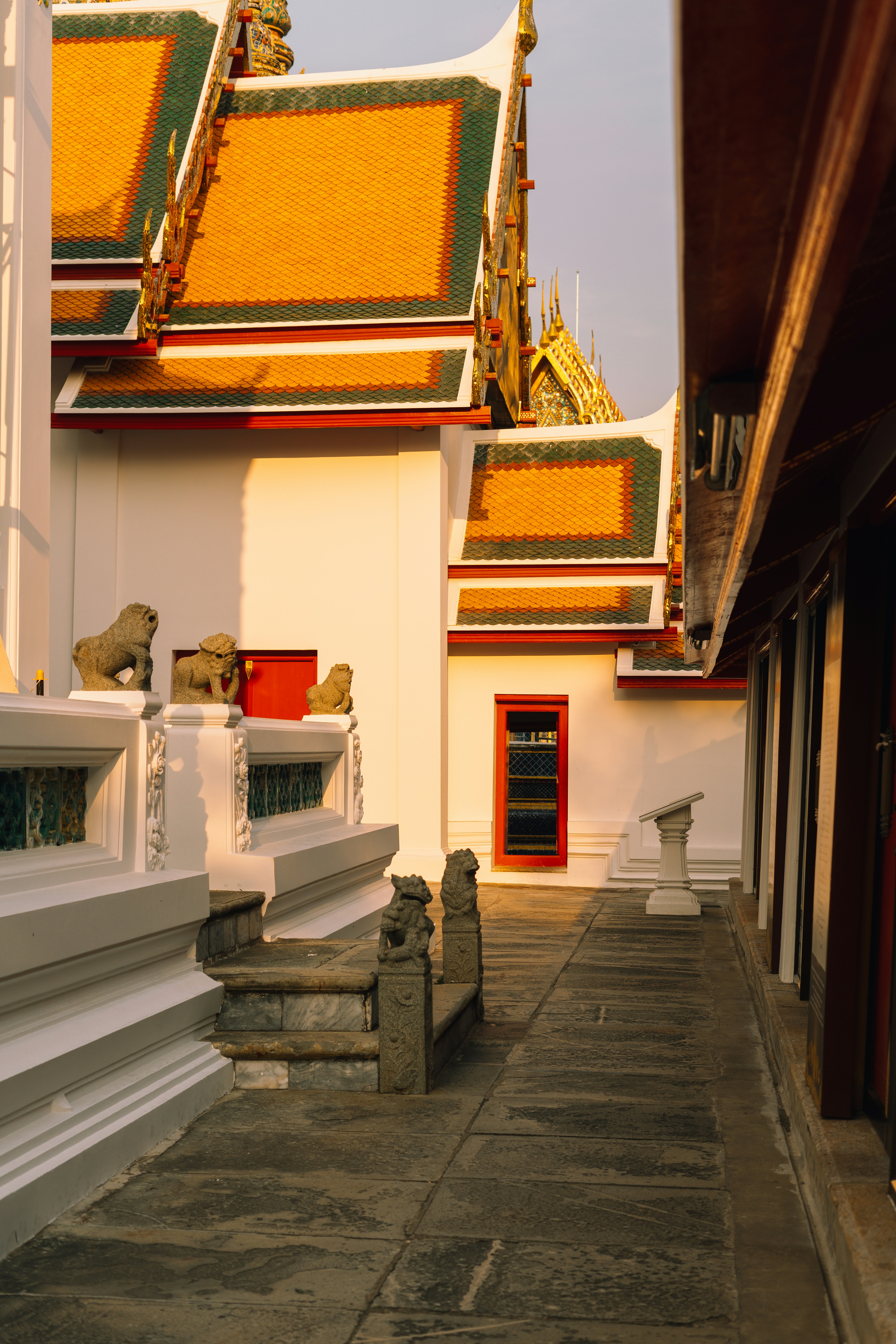 Sunlit Temple Facades: Geometric Rooftop Colors and Shaded Corridor