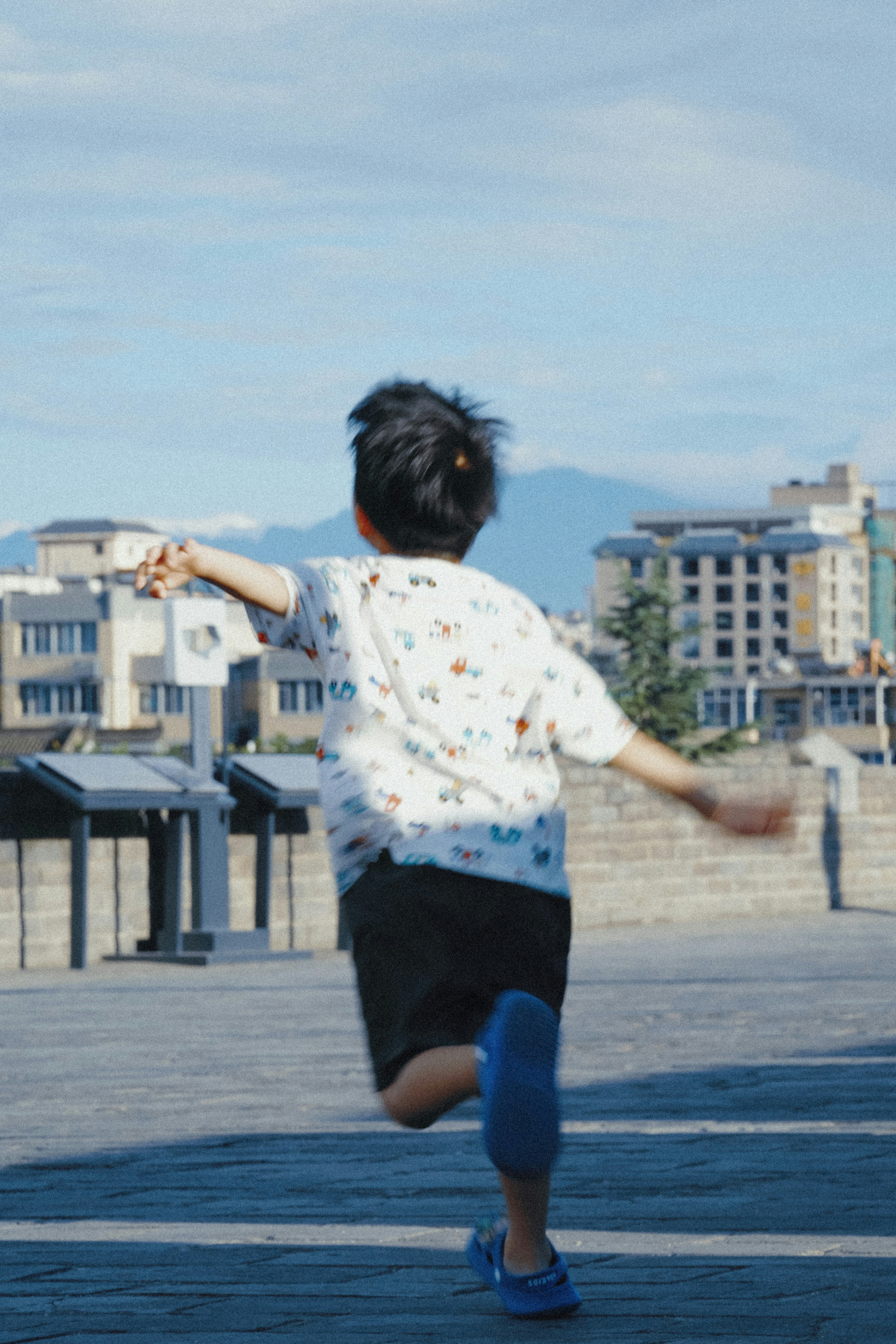 Child in Flight: A Moment of Free Run Across an Urban Terrace