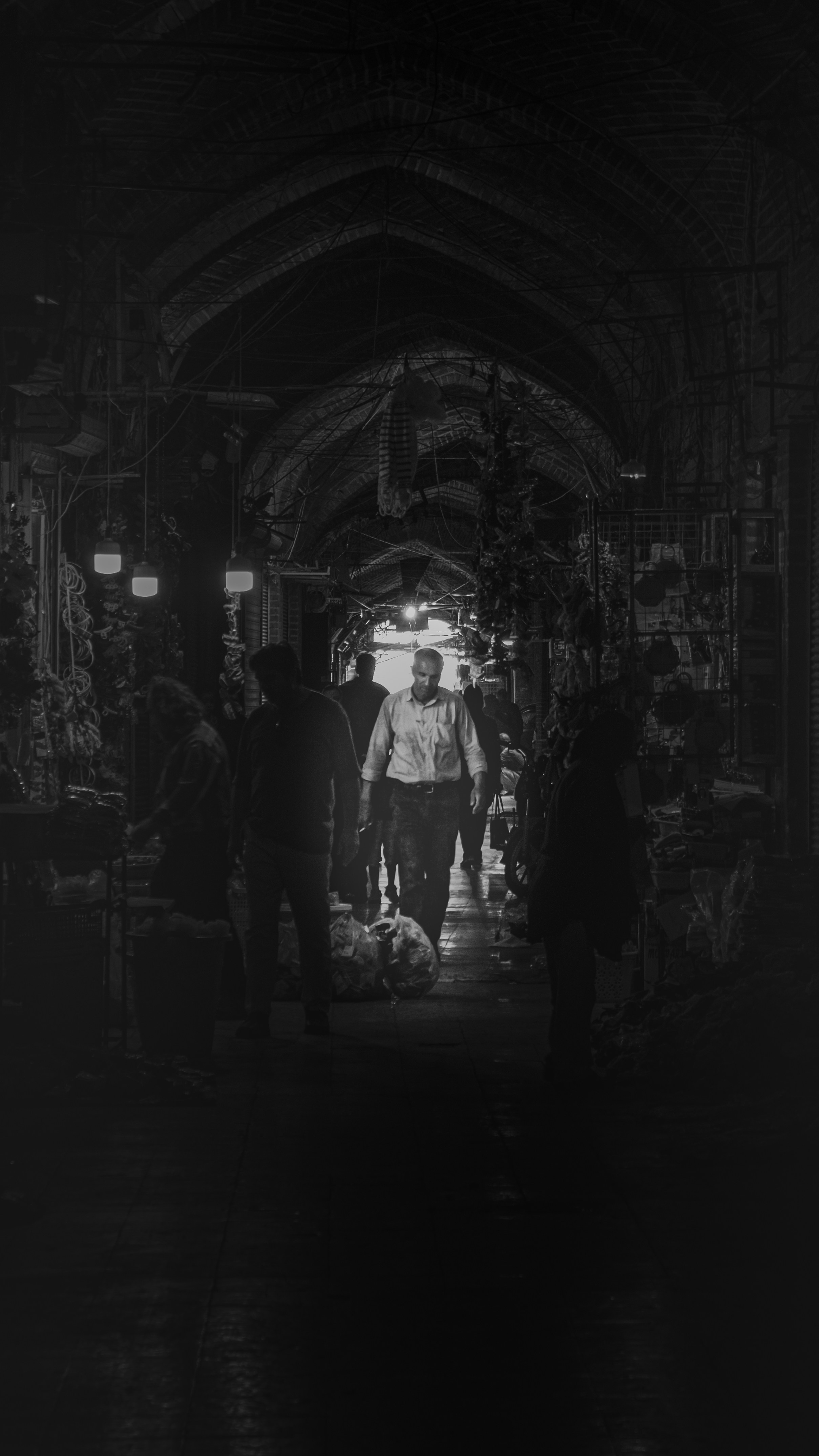 Midnight Bazaar: A Lone Figure Illuminates a Shadowed Market Corridor