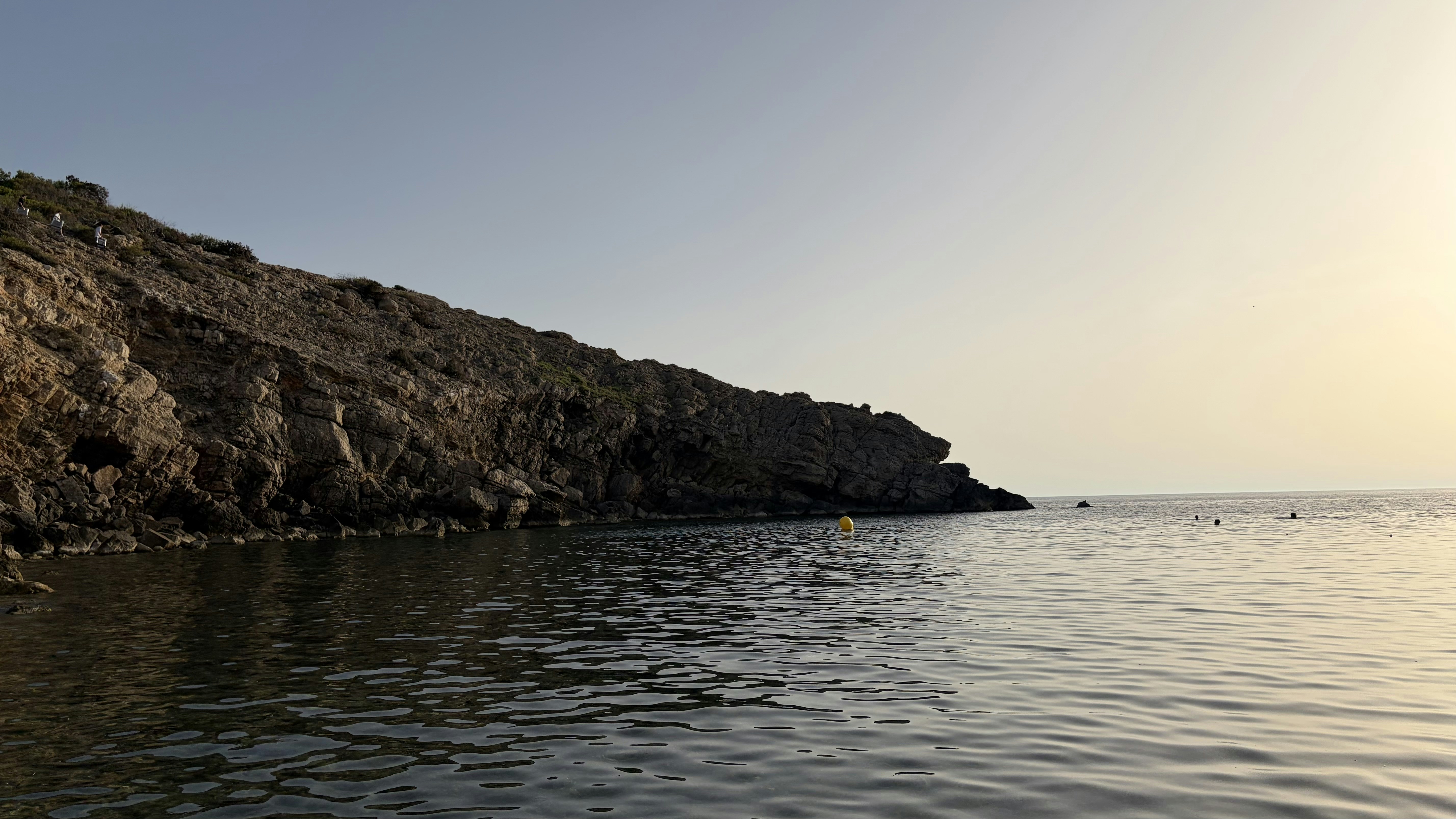 Sunlit Cove: Cliffside Shoreline at Dusk