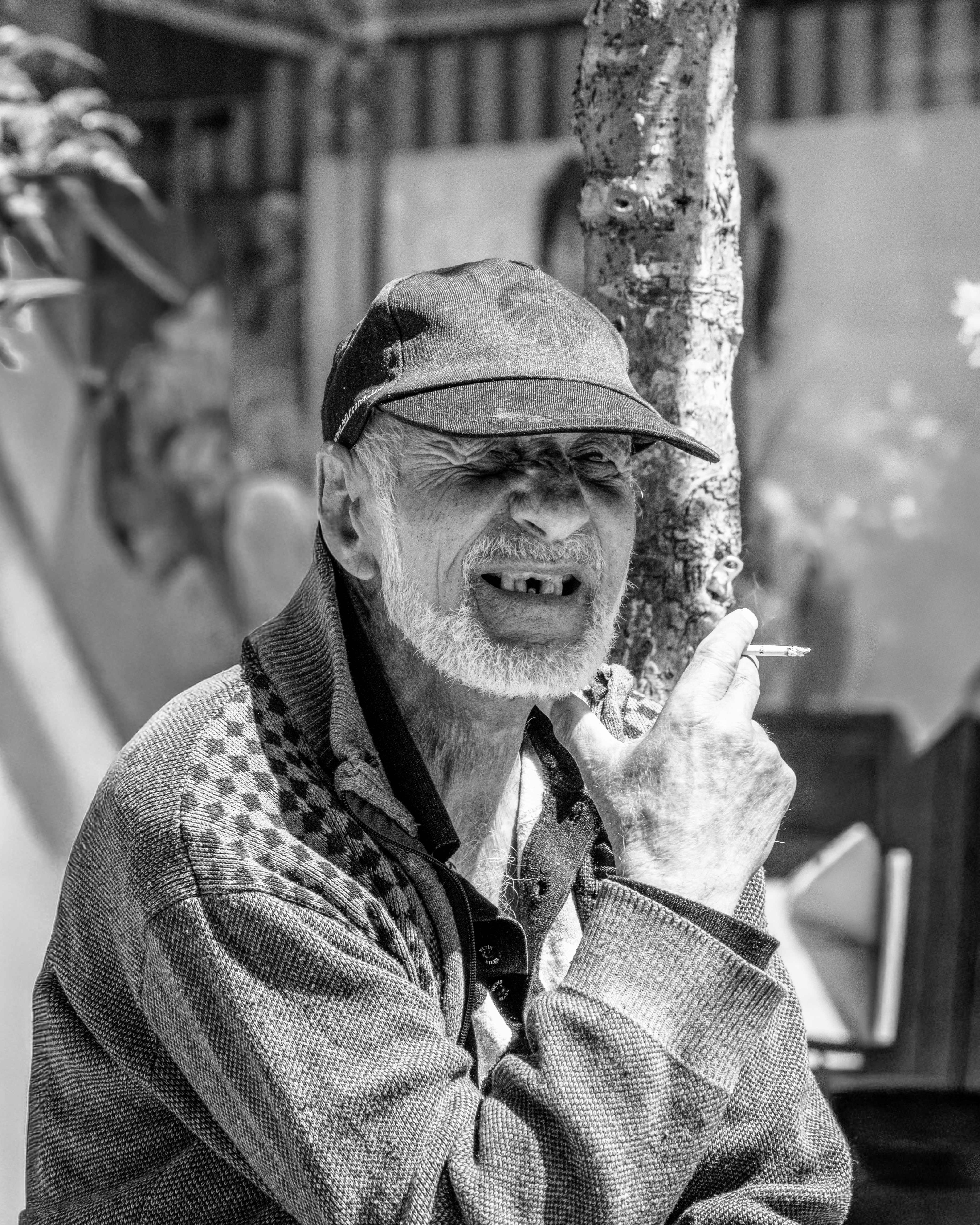 Grizzled Smoker in Shade: Portrait of a Weathered Everyday Moment