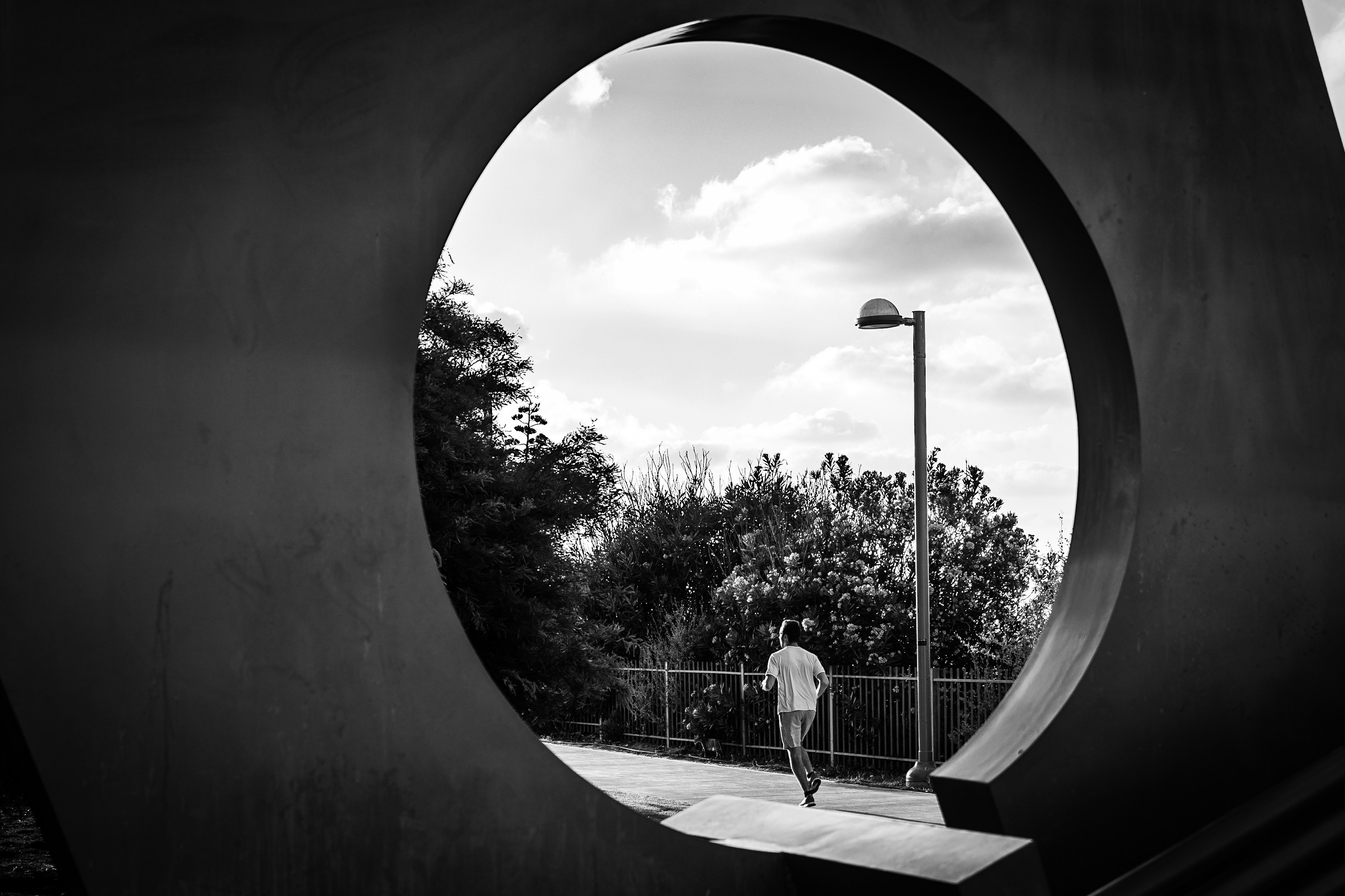 Through the Circular Frame: A Lone Walker in Morning Light