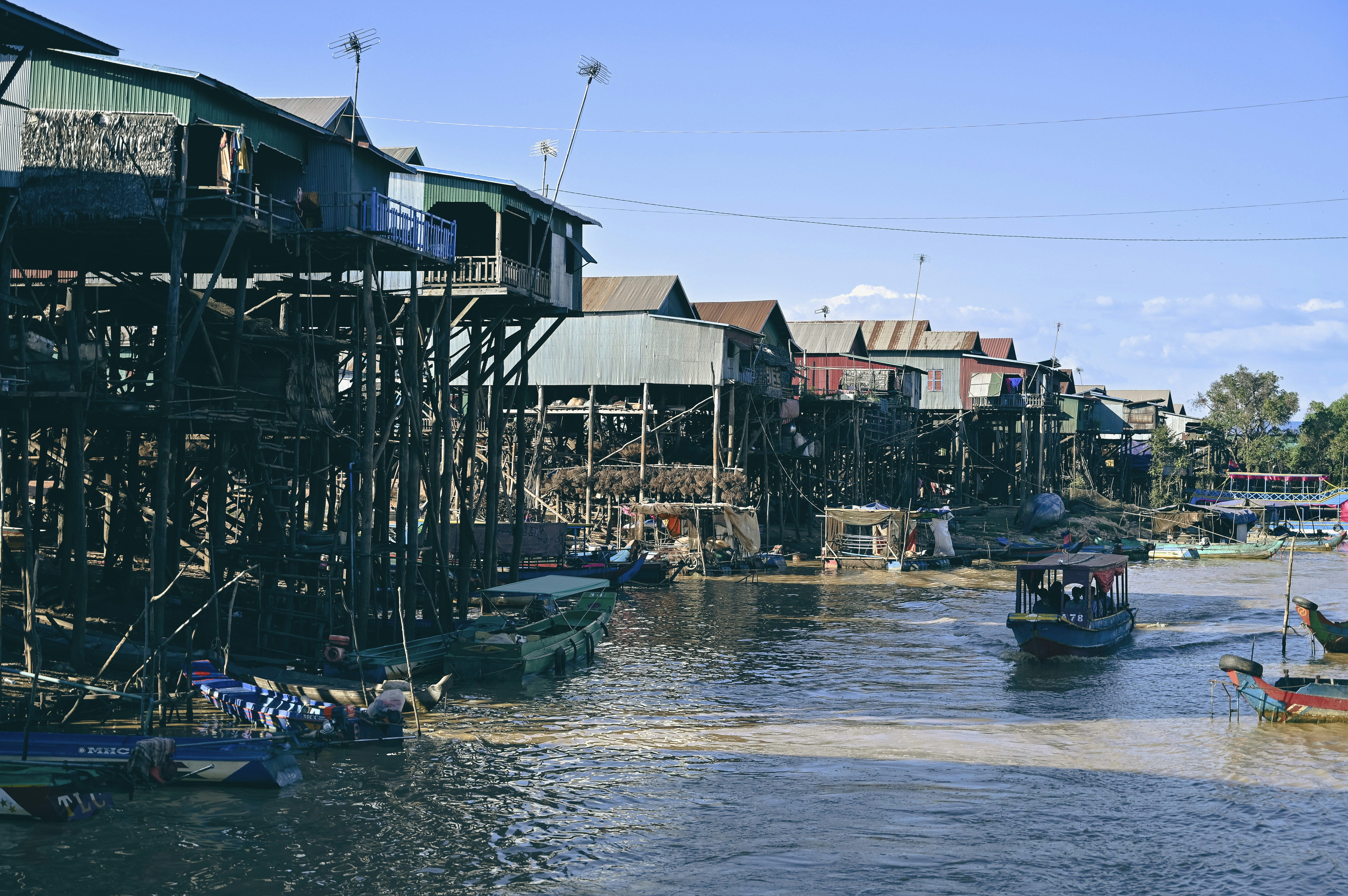 Stilted Riverscape: Boats Drift Along a Mangrove Stilt Village