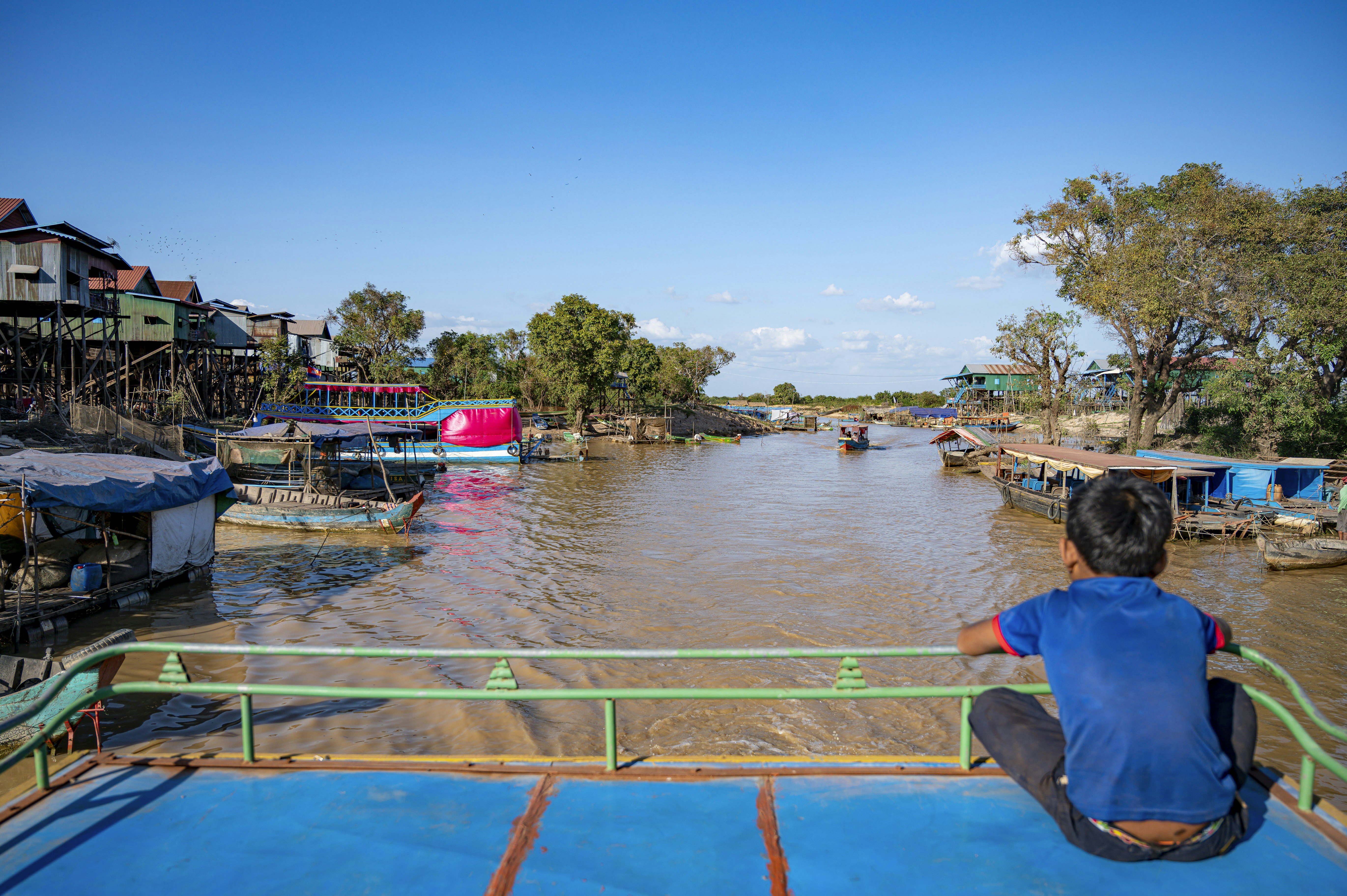 Front-Row View from a Boat: The Boy at the Riverside Channel