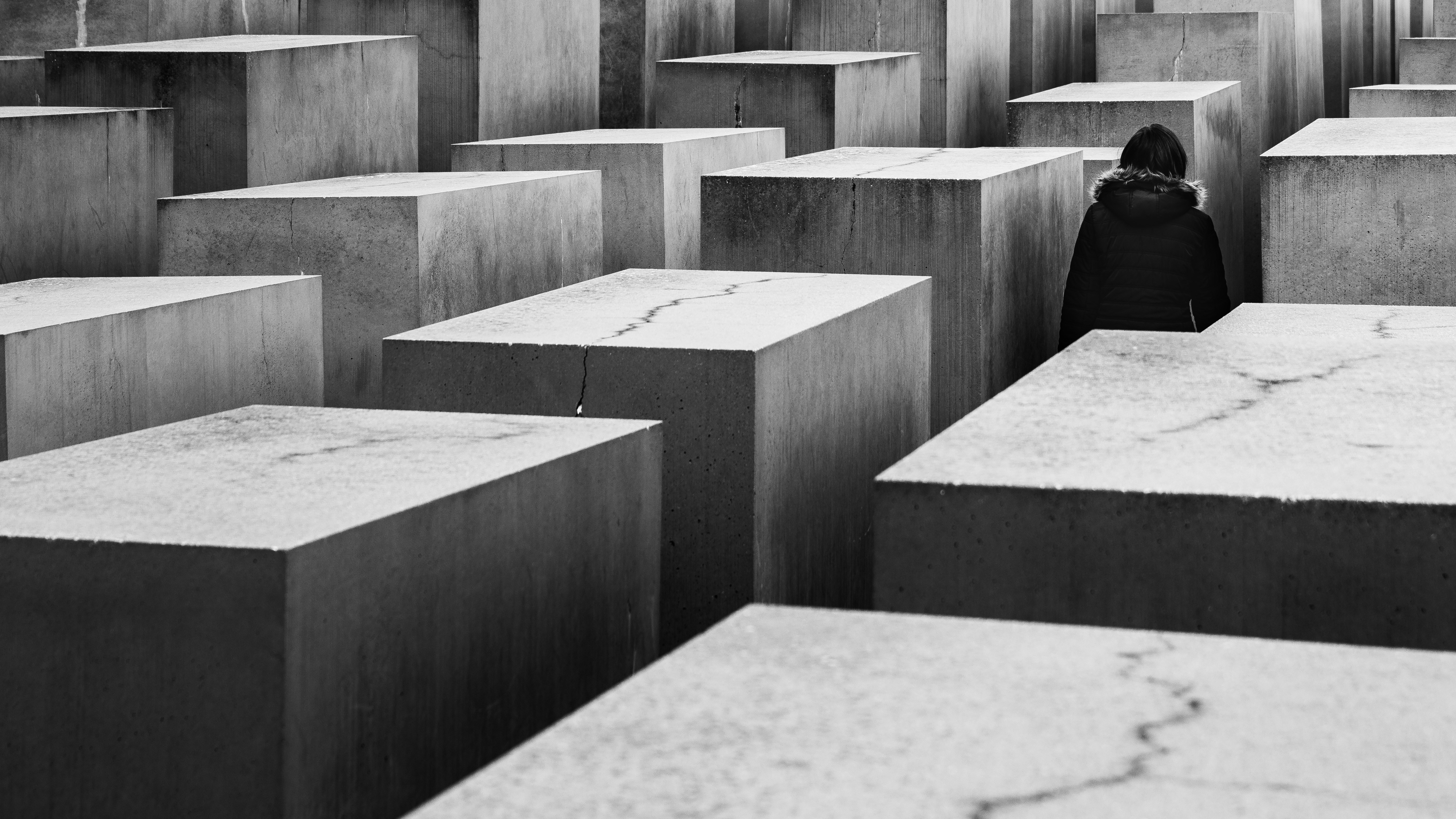 Alone Among the Monoliths: A Figure at the Edge of the Grid