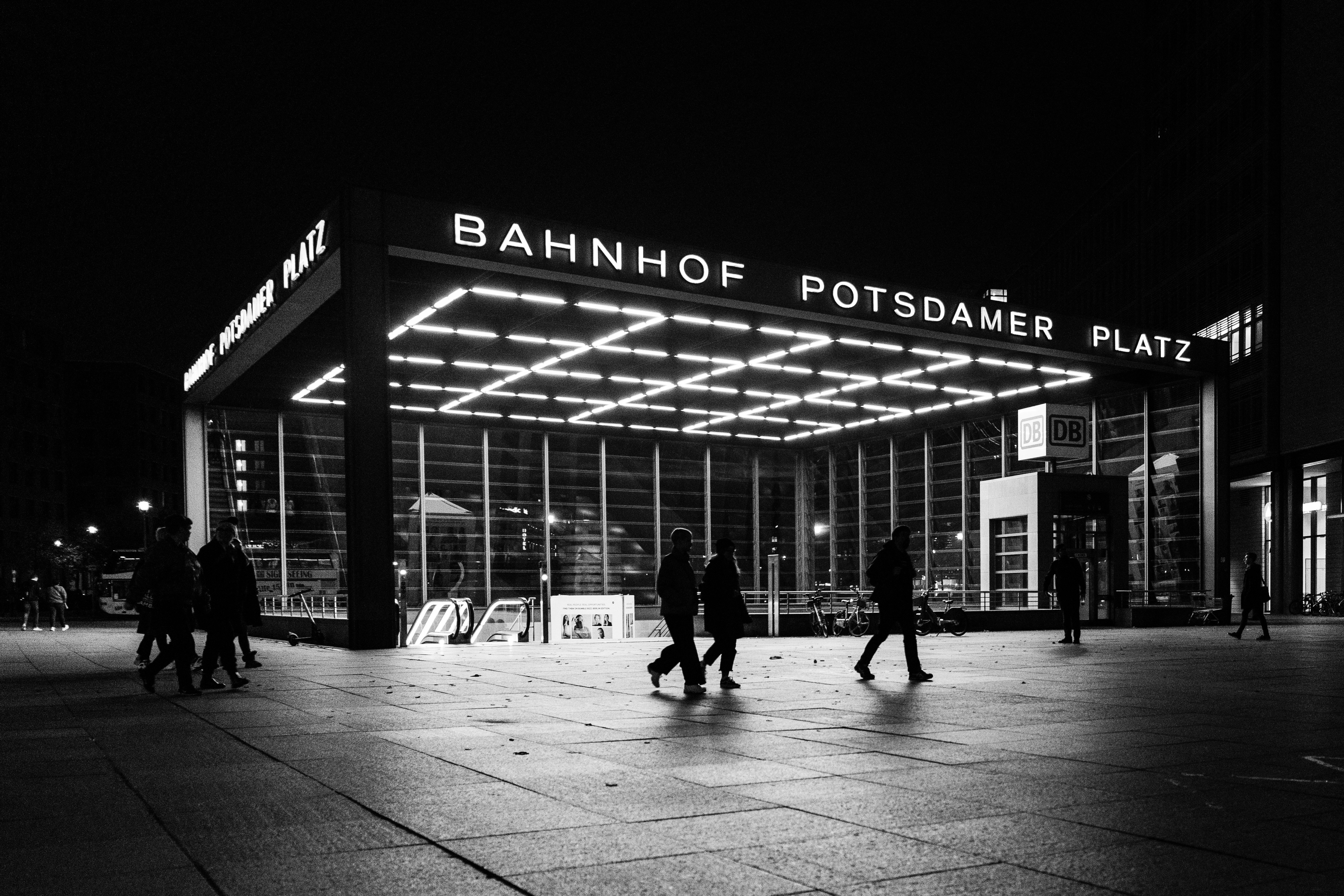 Night at the Potsdamer Nexus: Illuminated Entrance under the Bahnhof Sign