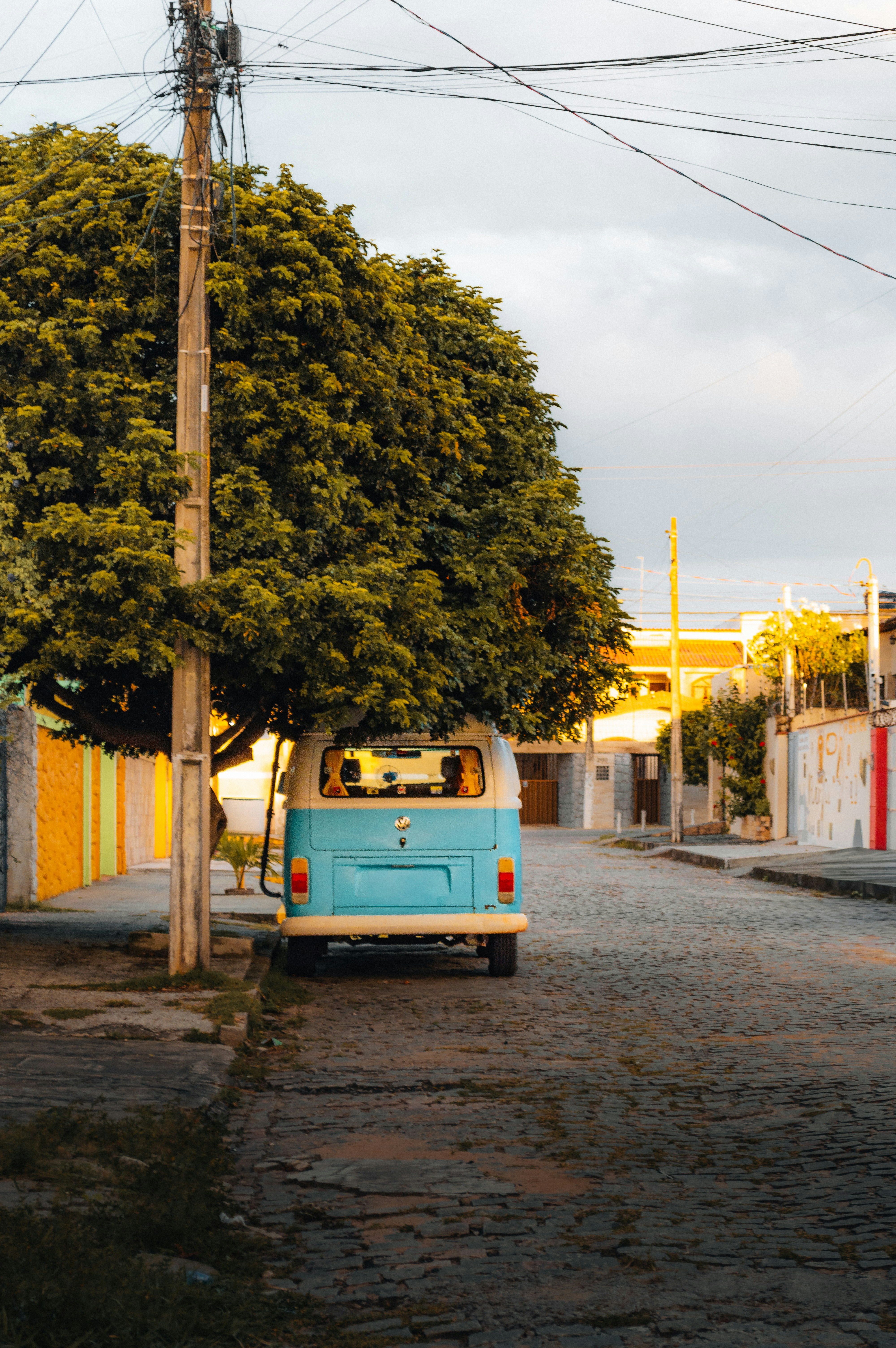 Blue Bus on a Sunlit Cobblestone Street