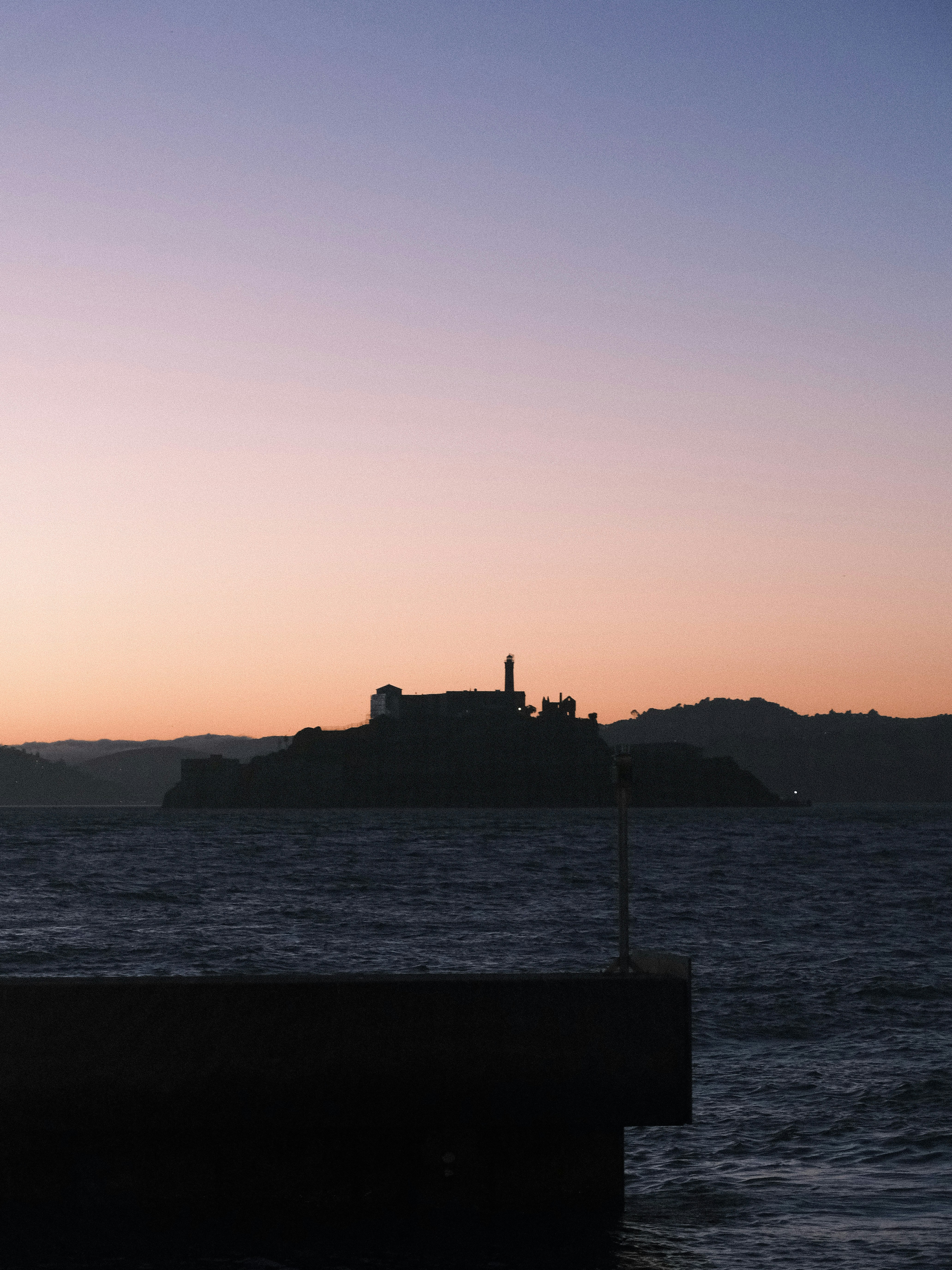 Sunset silhouette: fortress island on calm water