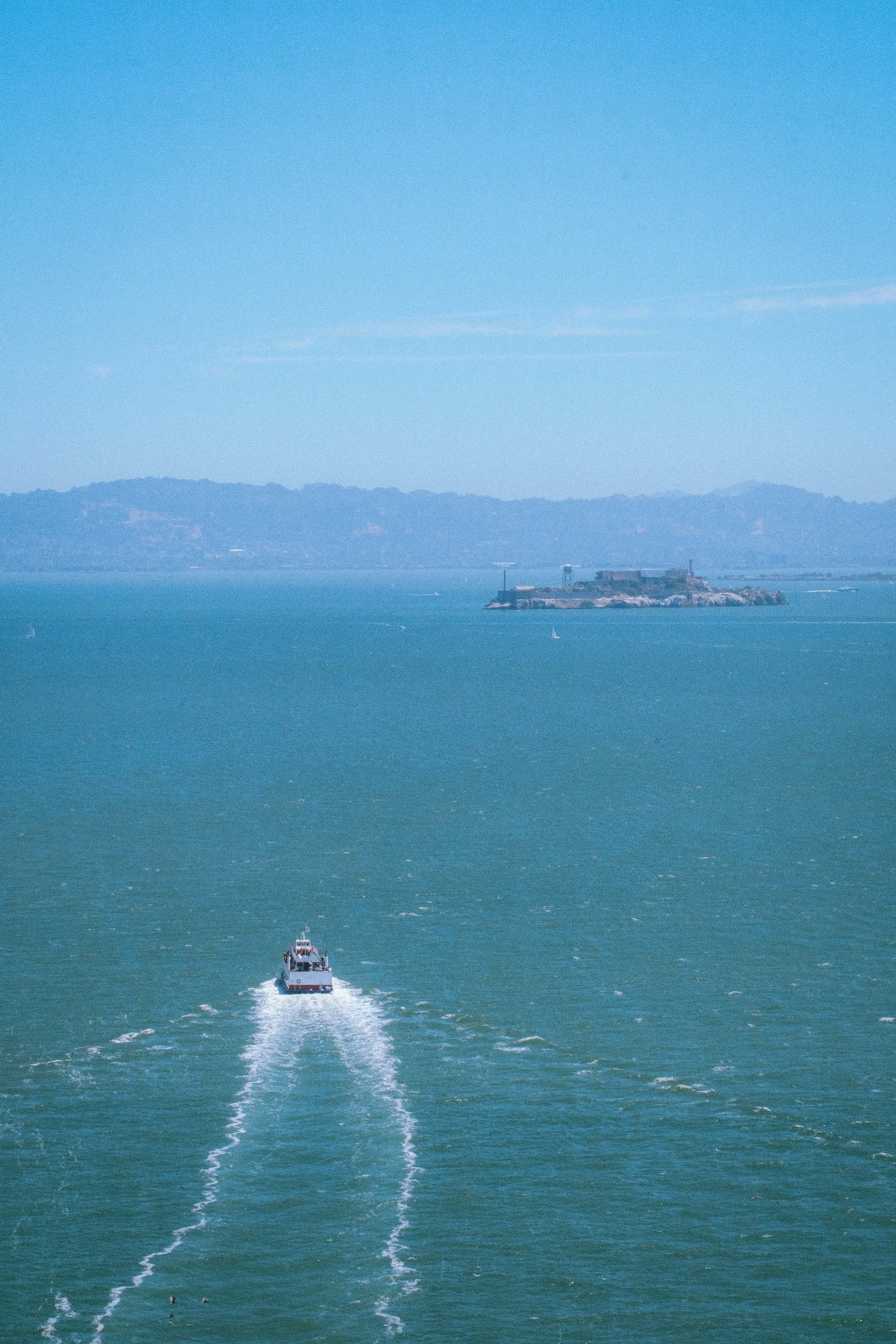 Vessel's Wake toward a Misty Island Horizon