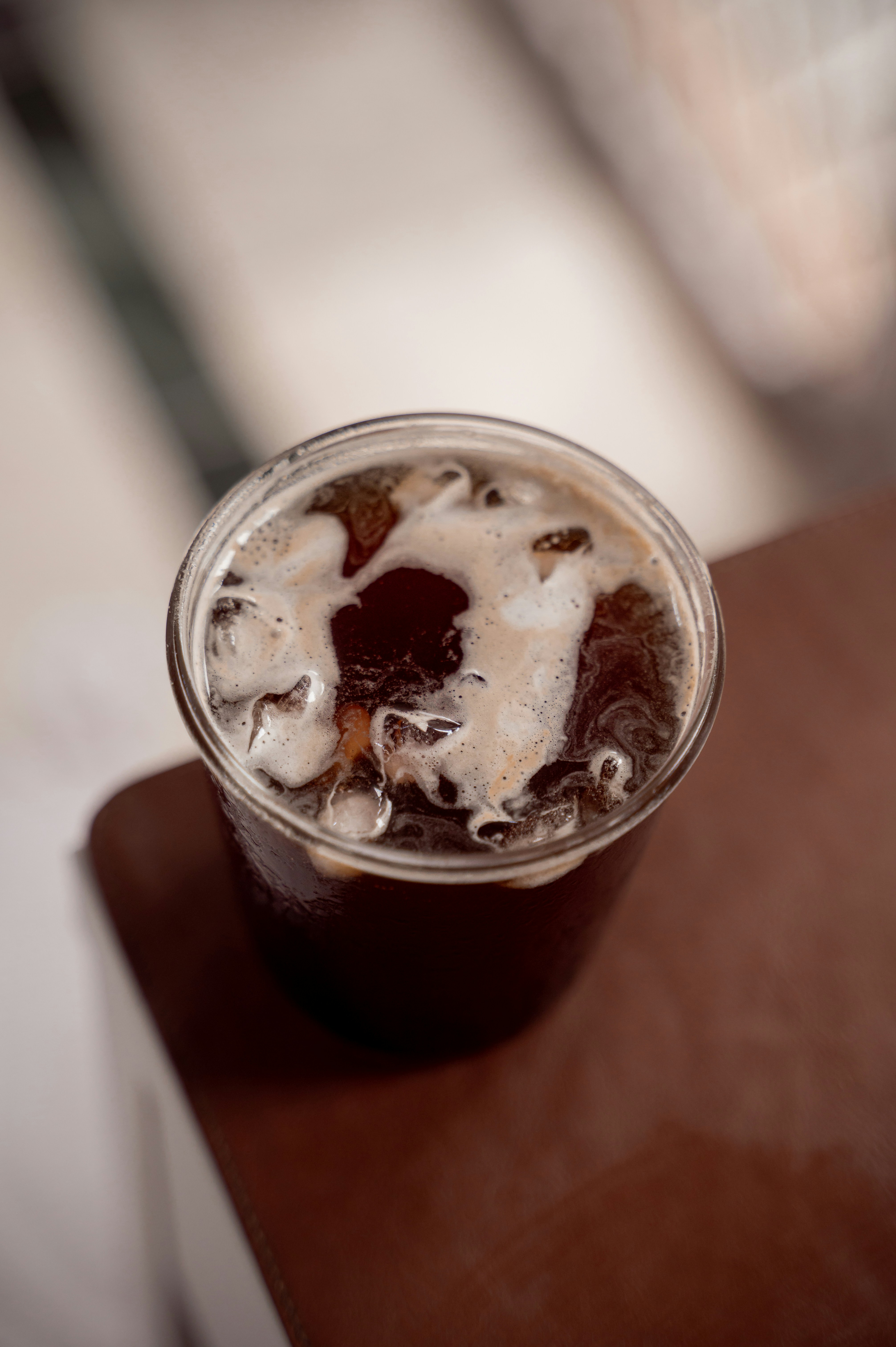 Frosted Coffee Circles: A Top-Down View of a Glass on Leather