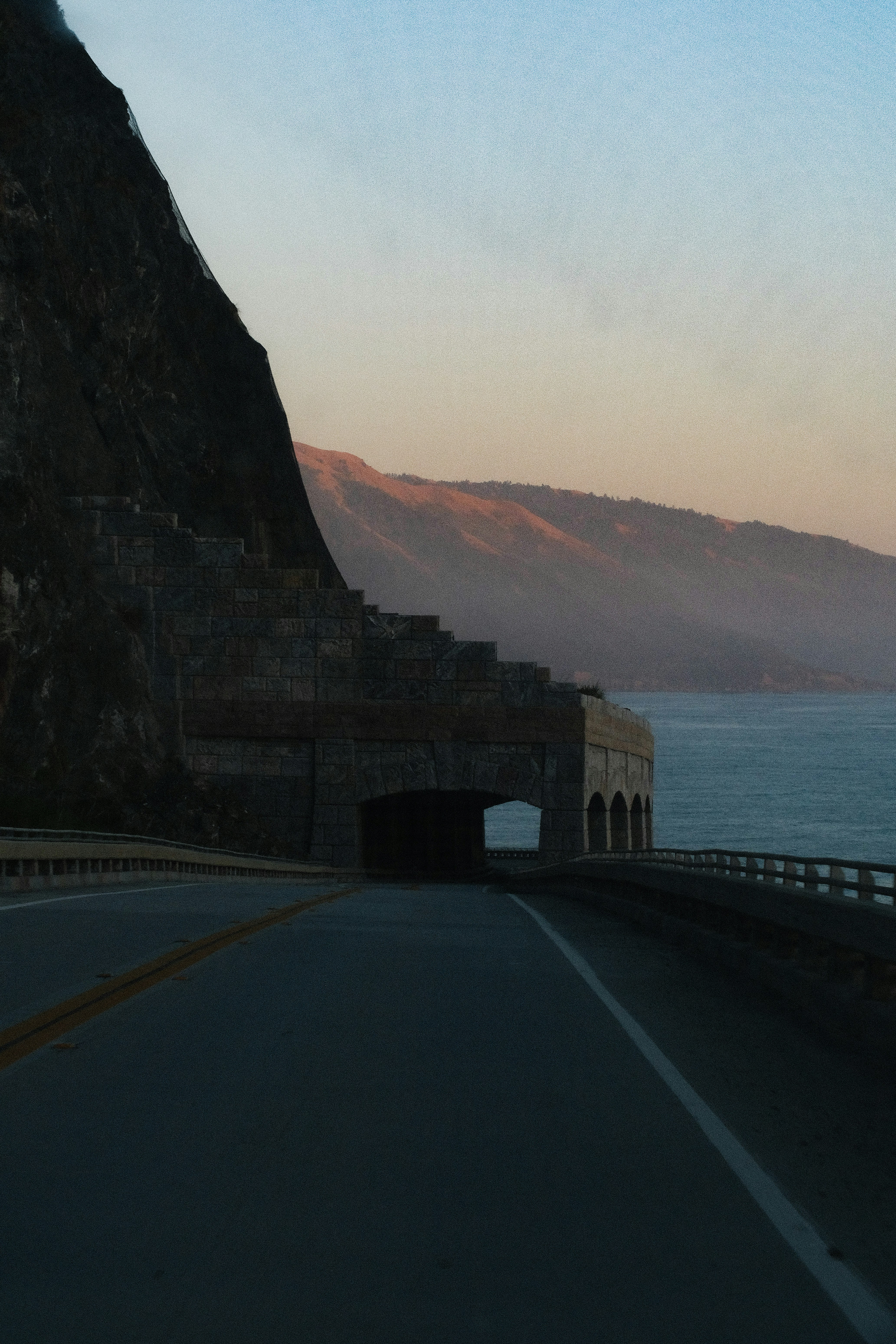 Coastal Road Through Shadowed Cliffs