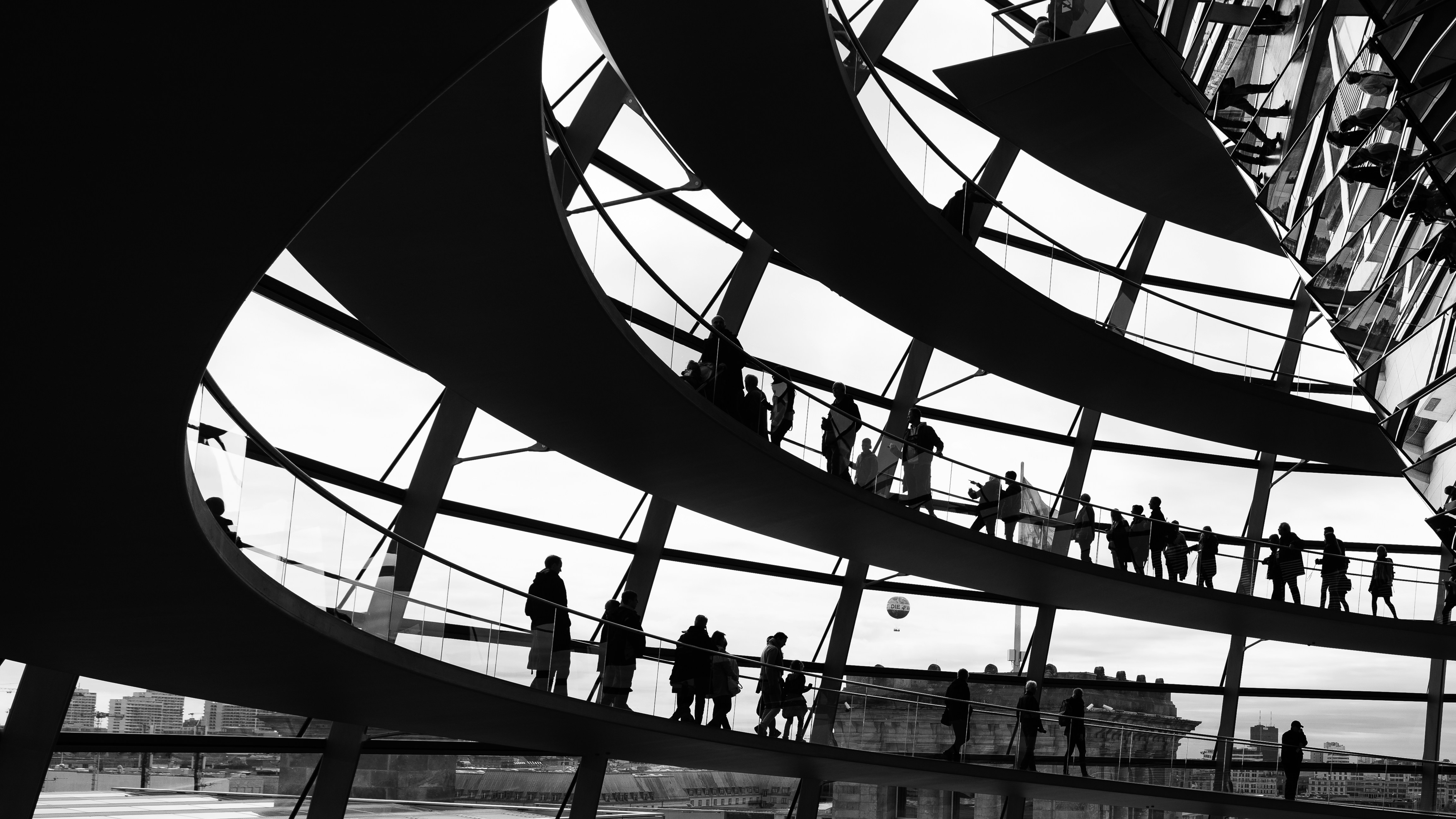 Spiral Glasses: People Silhouetted in a Black-and-White Atrium
