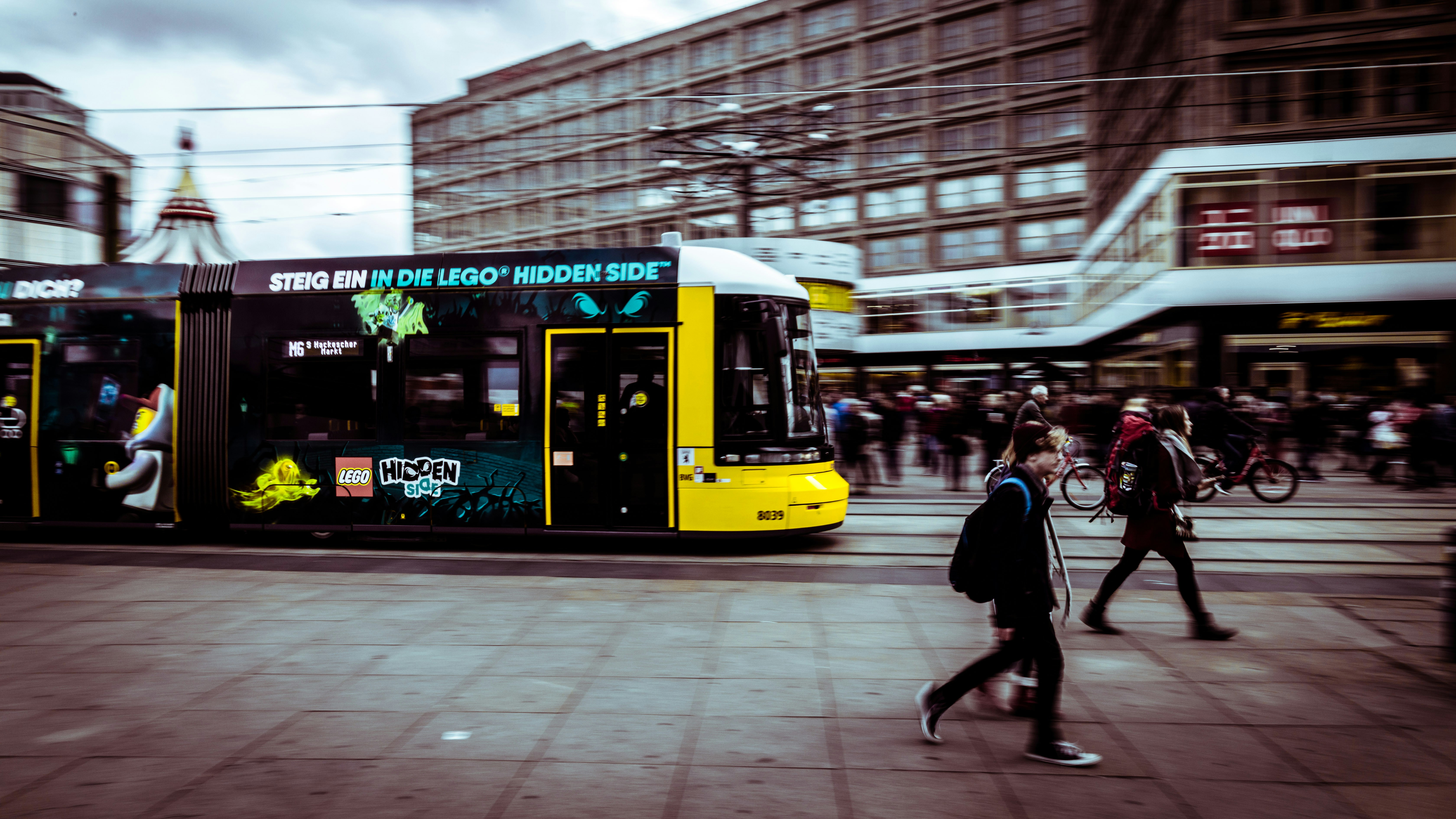 Yellow tram gliding through a busy urban square