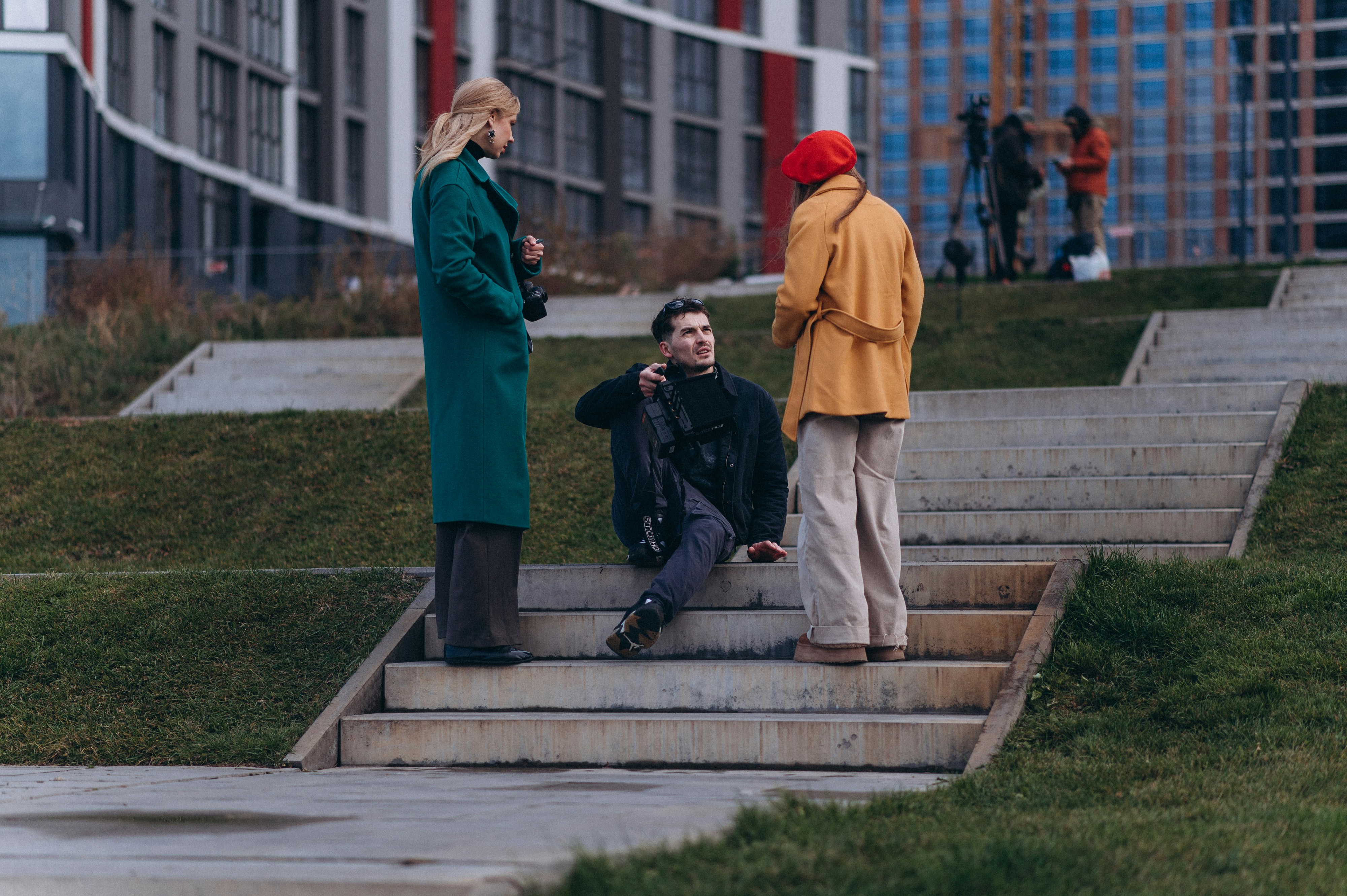 Urban chorus on steps: a photographer chats with a trio beneath modern towers
