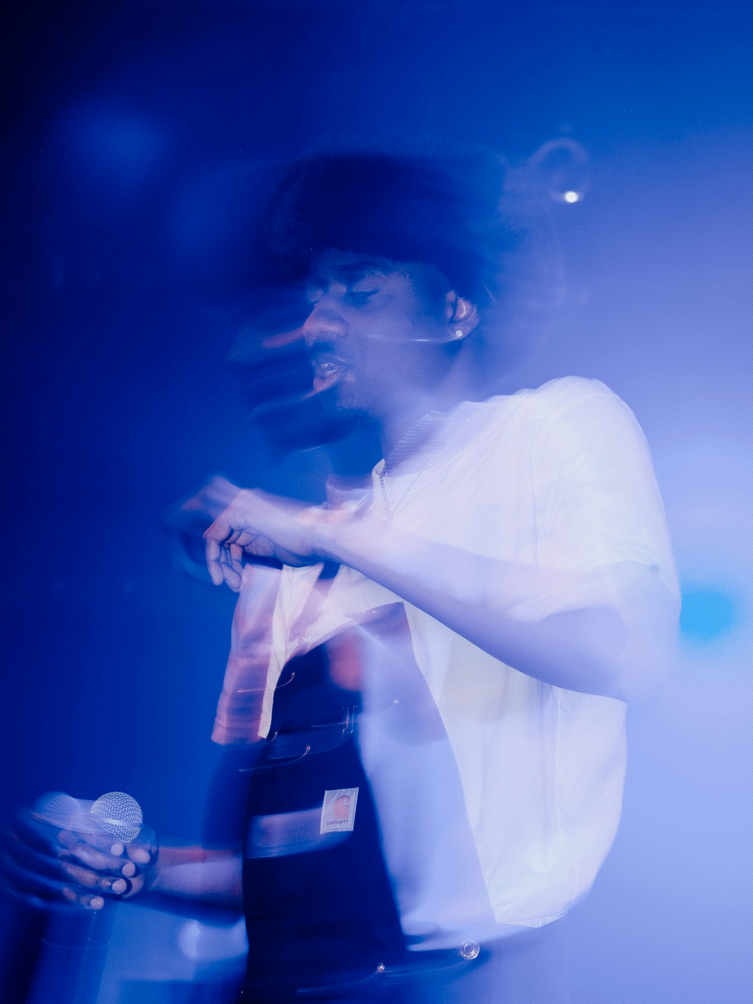 Blue Illusion on Stage: A Blurred Performer in Motion
