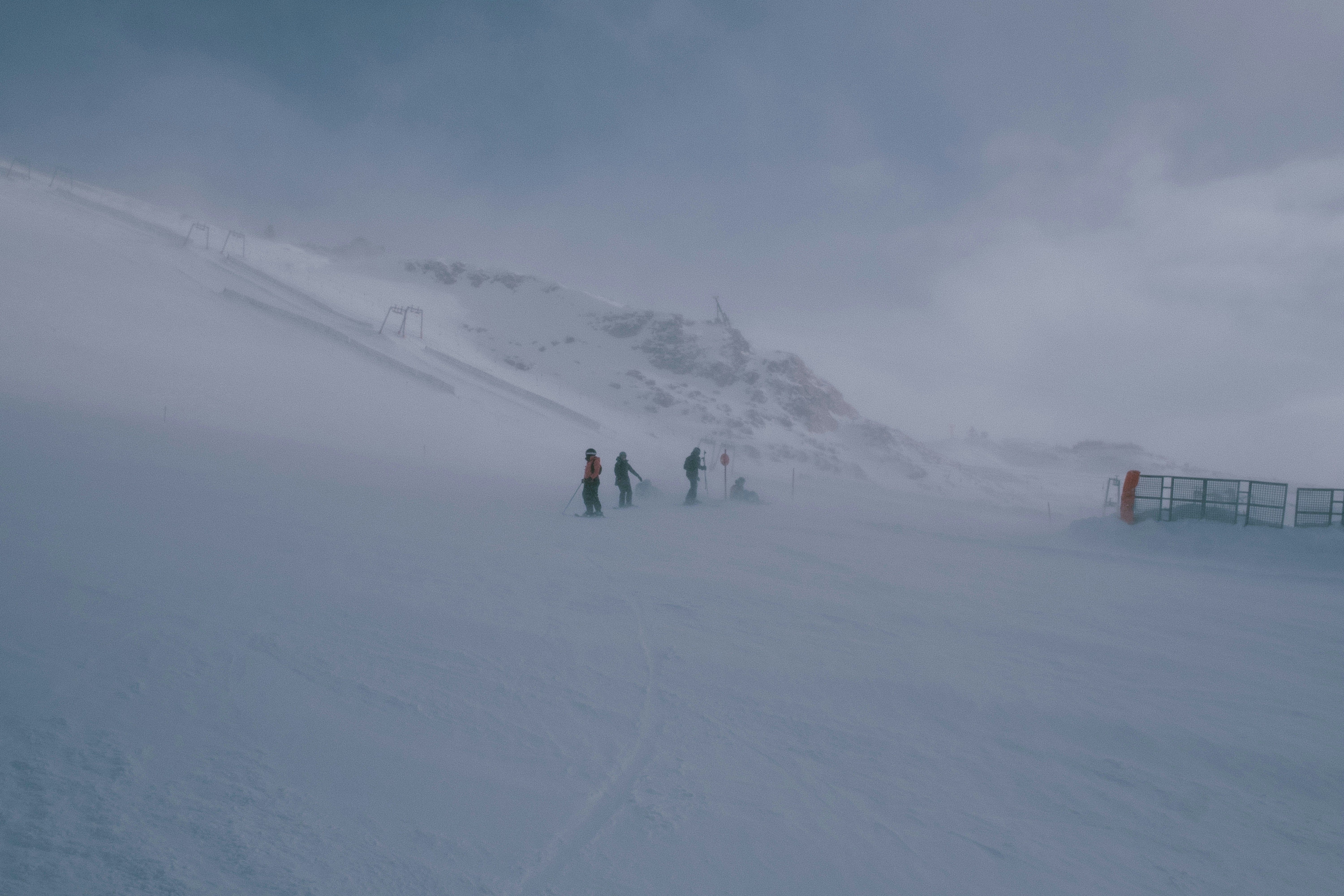 Trail of Three Climbers Beneath a Bleached Sky
