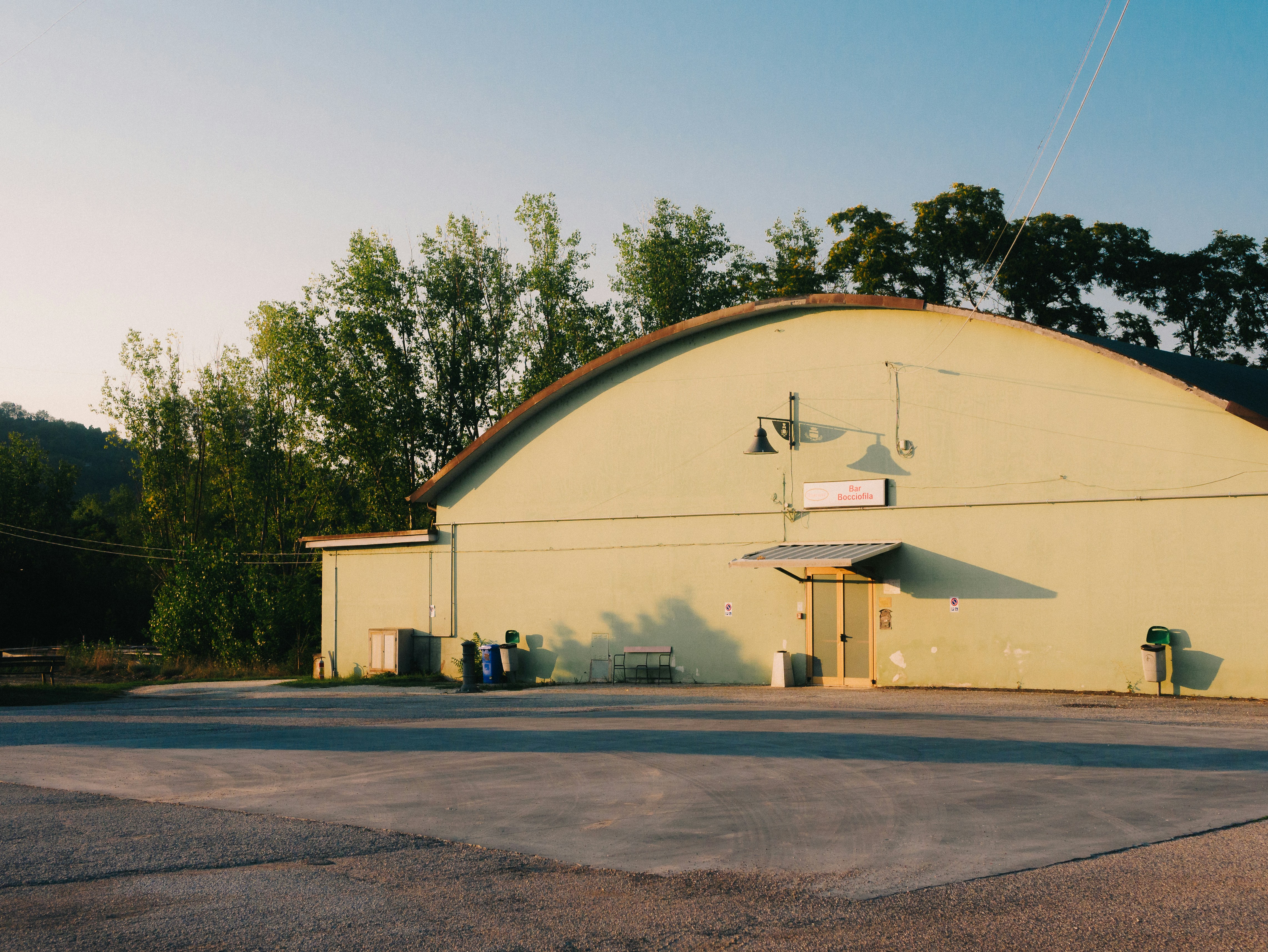 Sunlit Quonset Hall: Simple Backlot with Shadowed Doors