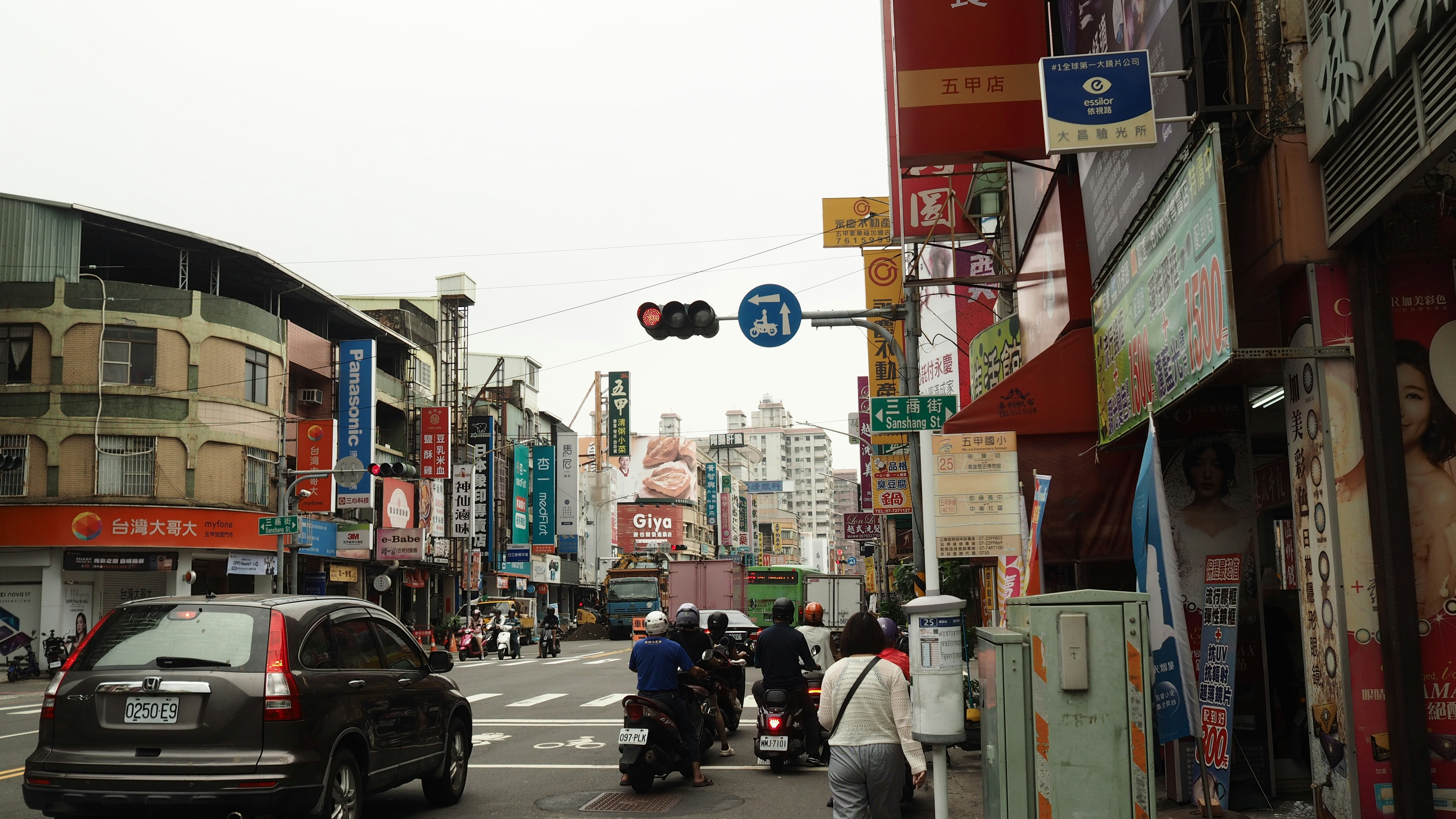 City Crossroads: Scooter Traffic and Neon Signage Converge