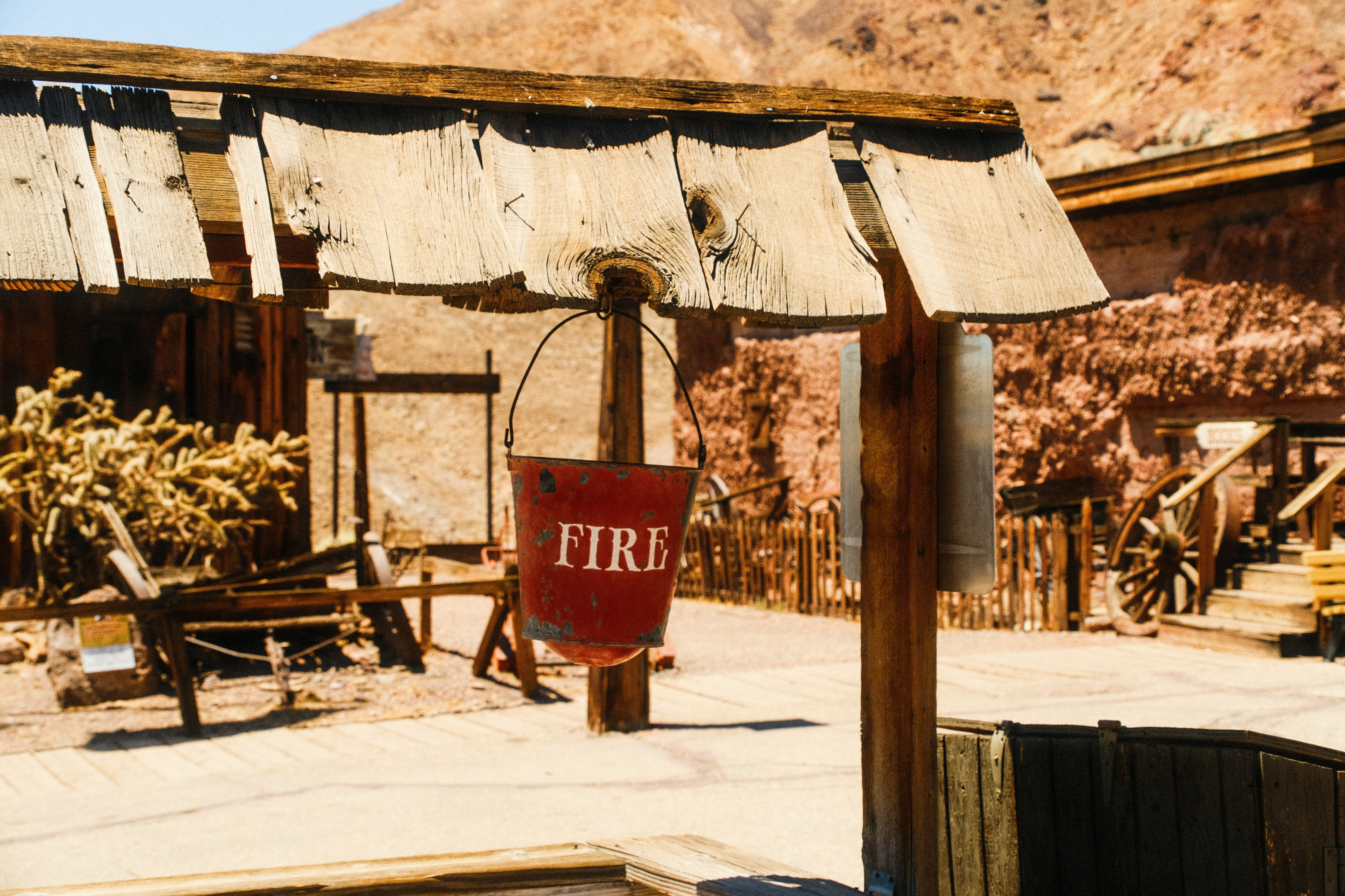 Red Bucket of Fire: A rustic, sunlit Western Set