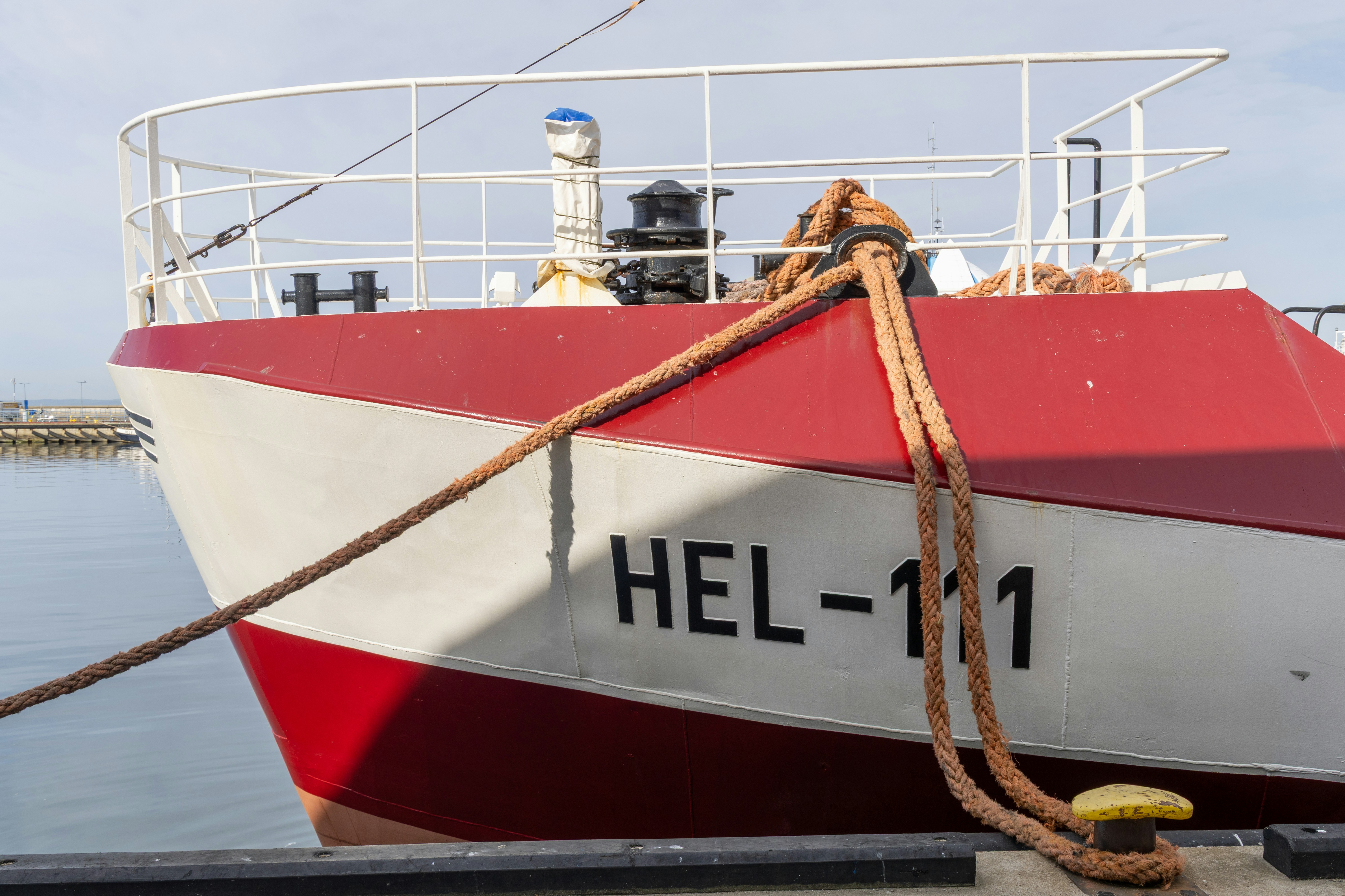 Roped Vessel: A Red-White Hull Basking at the Dock