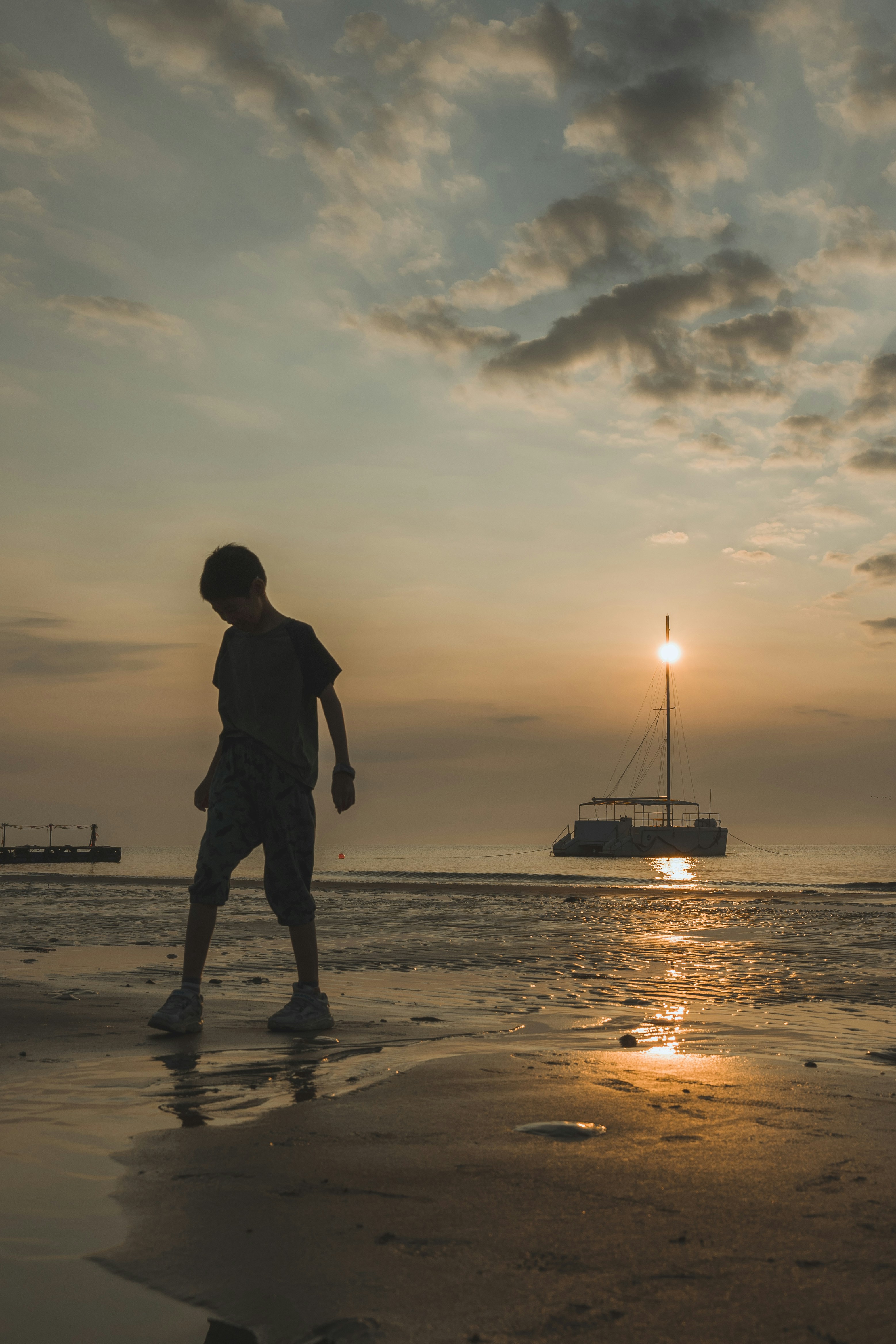 Child on the Shore at Golden Hour, Sailboat Silhouette Beyond