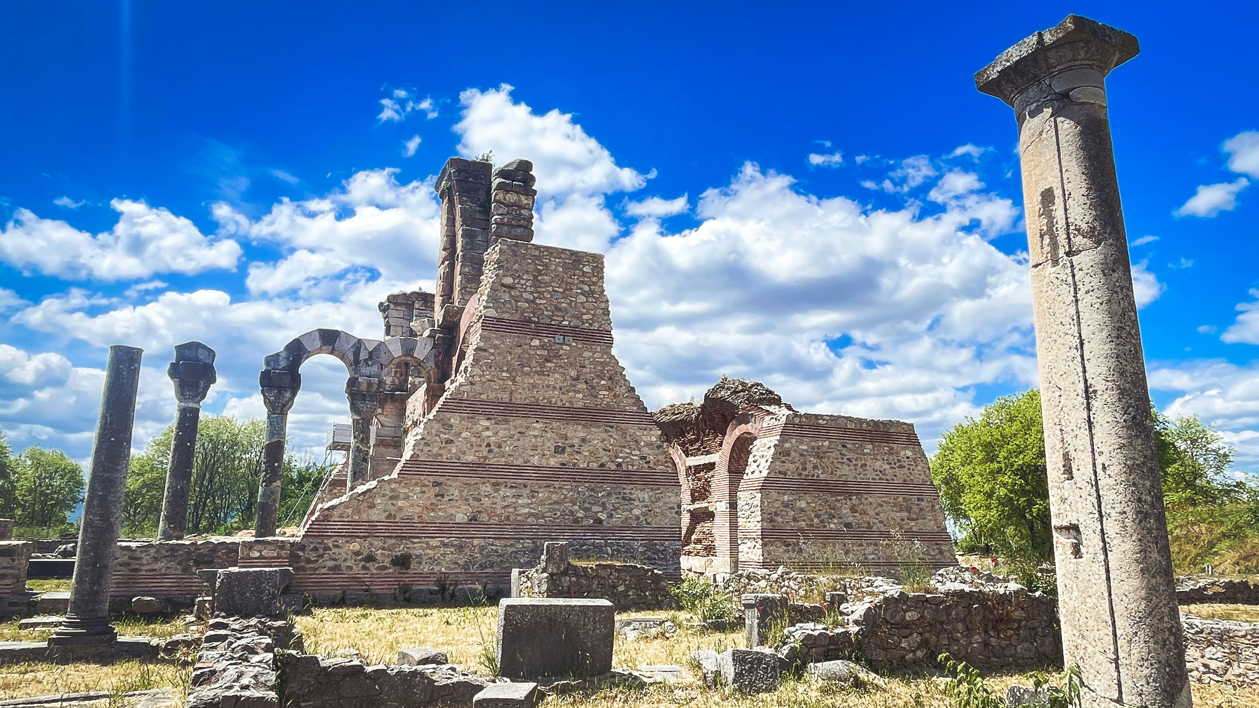Ruins Under a Bright Sky: Ancient Columns among Weathered Brickwork