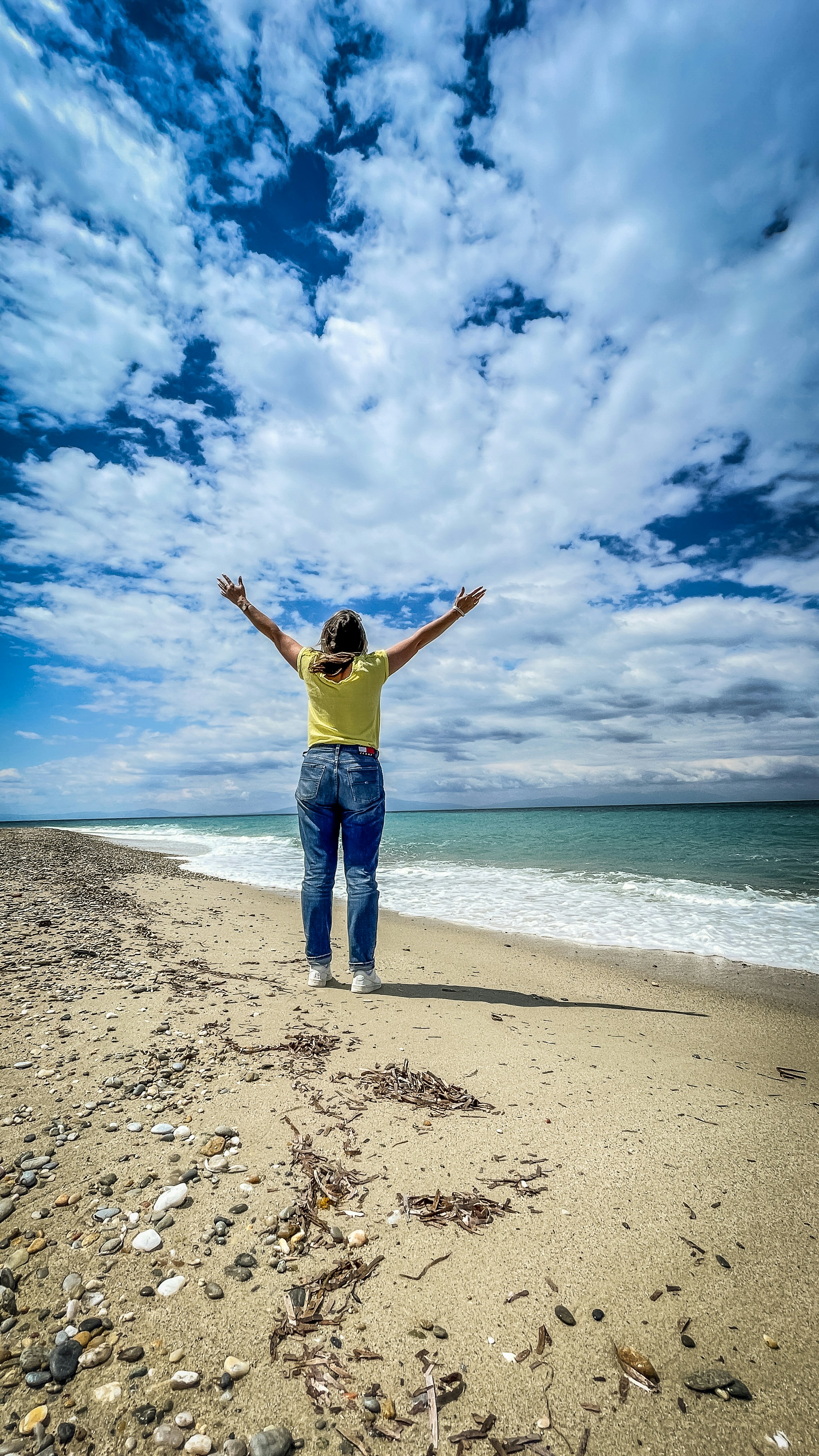 Wide Beachbound Embrace: A Figure Reaching Toward the Sky