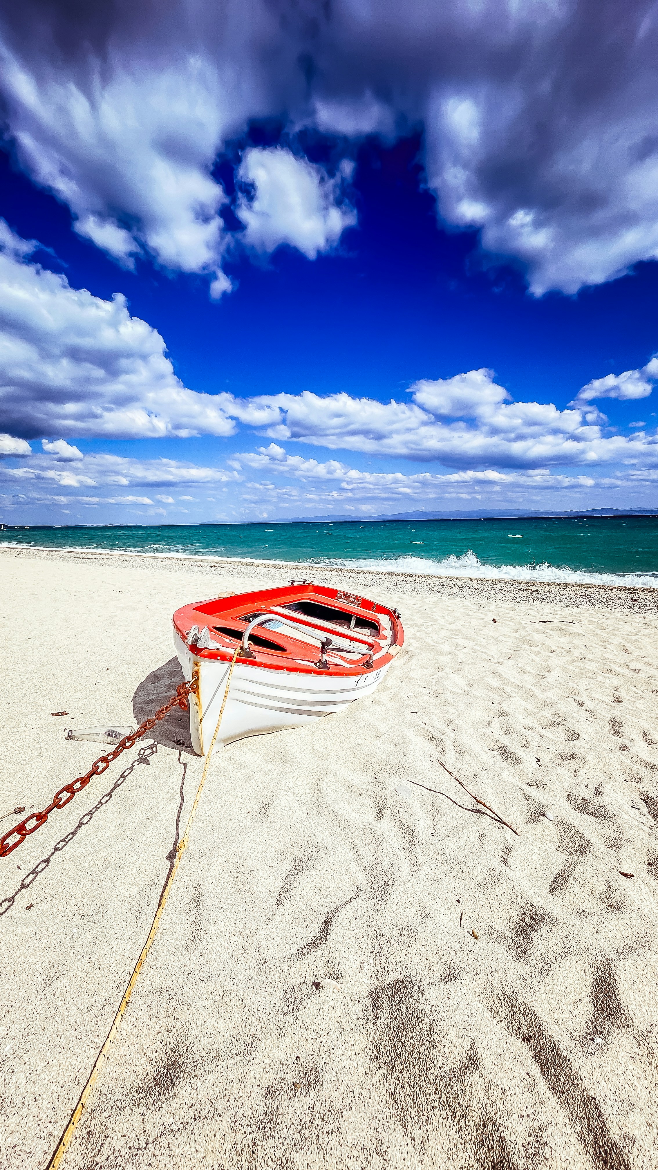 Red Boat on Sunlit Beach: A Sea of Blue and White