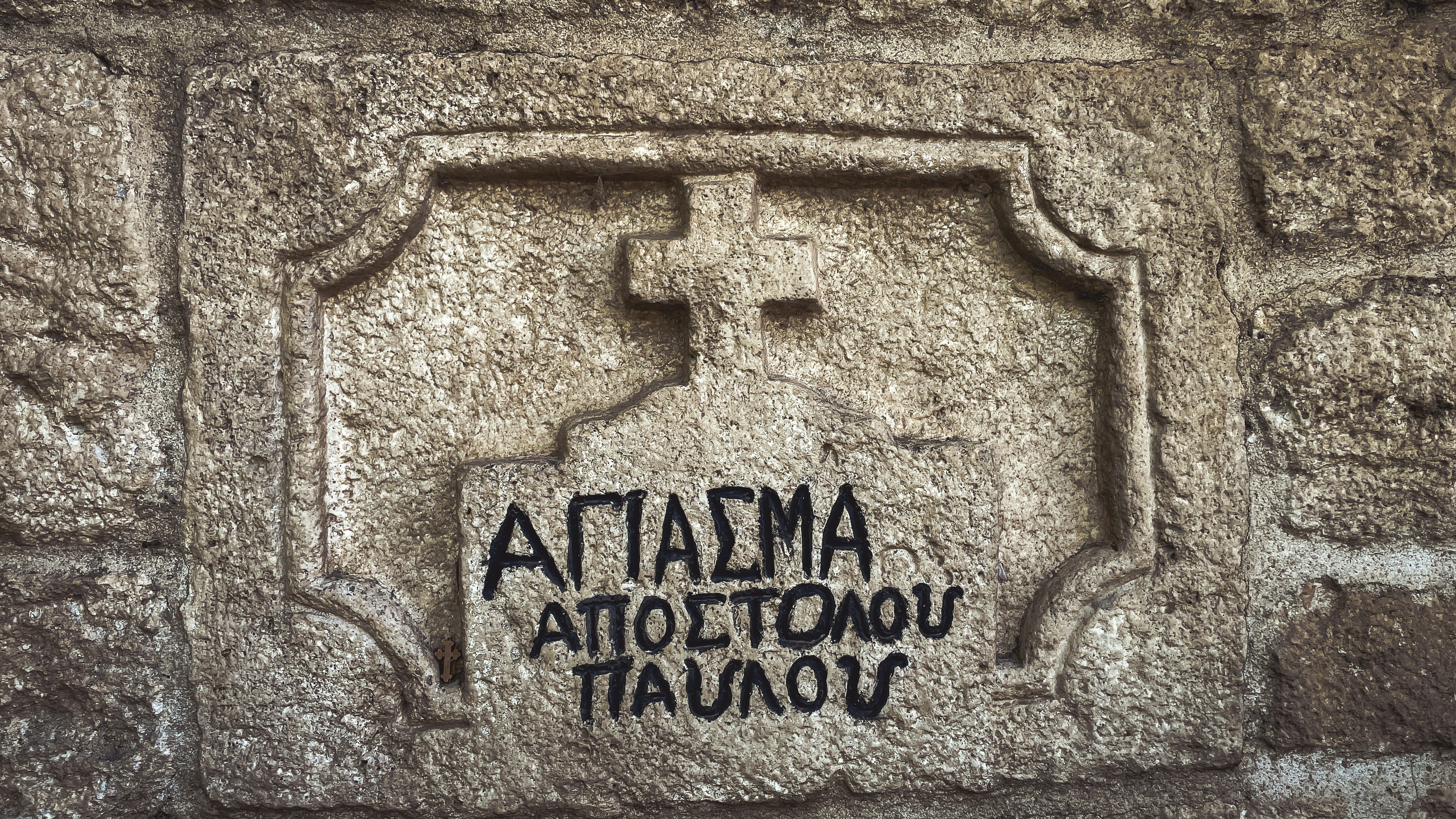 Carved Cross Inscription on Weathered Stone Wall