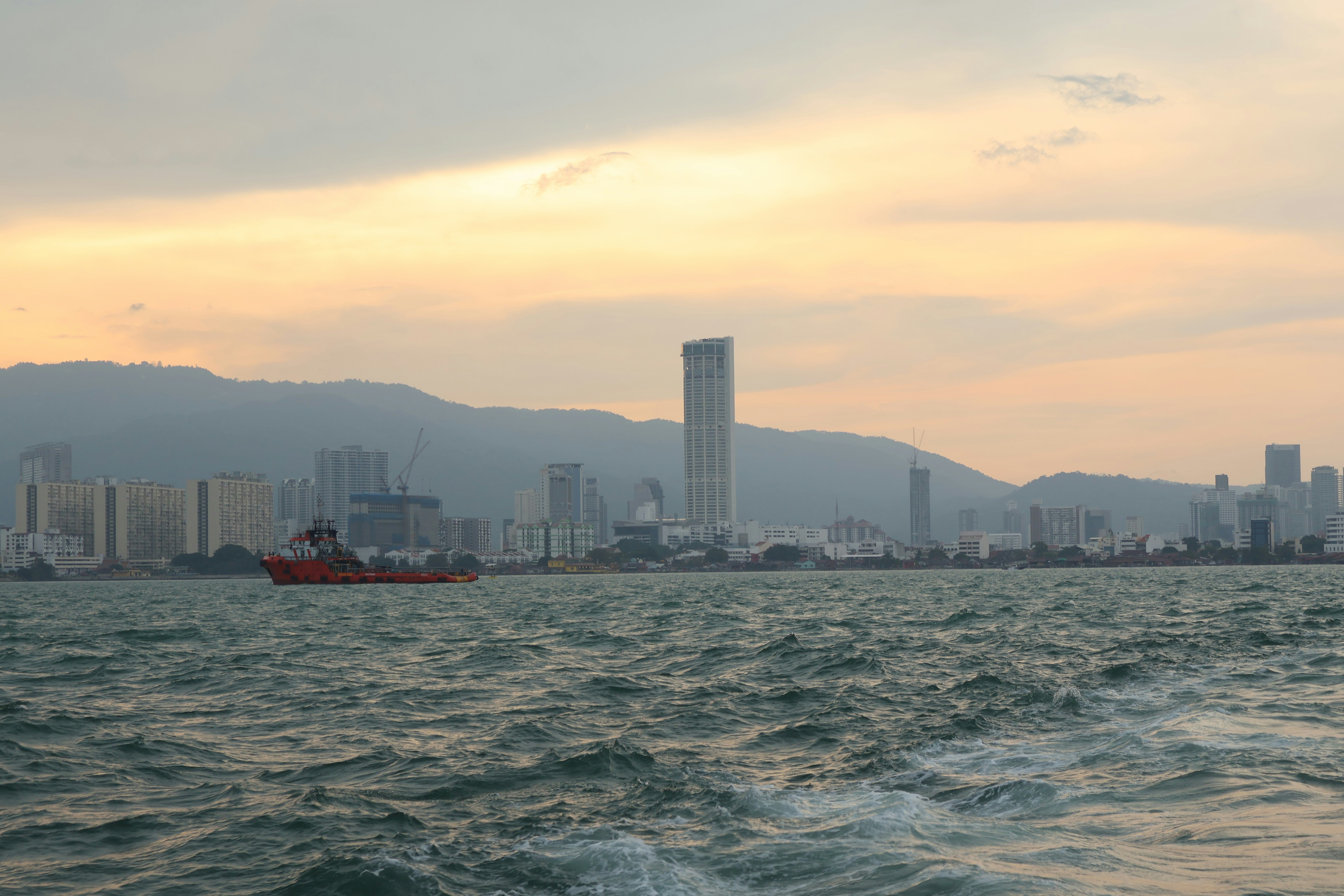 Dawn Over the Harbor: City Silhouette Against Rolling Sea