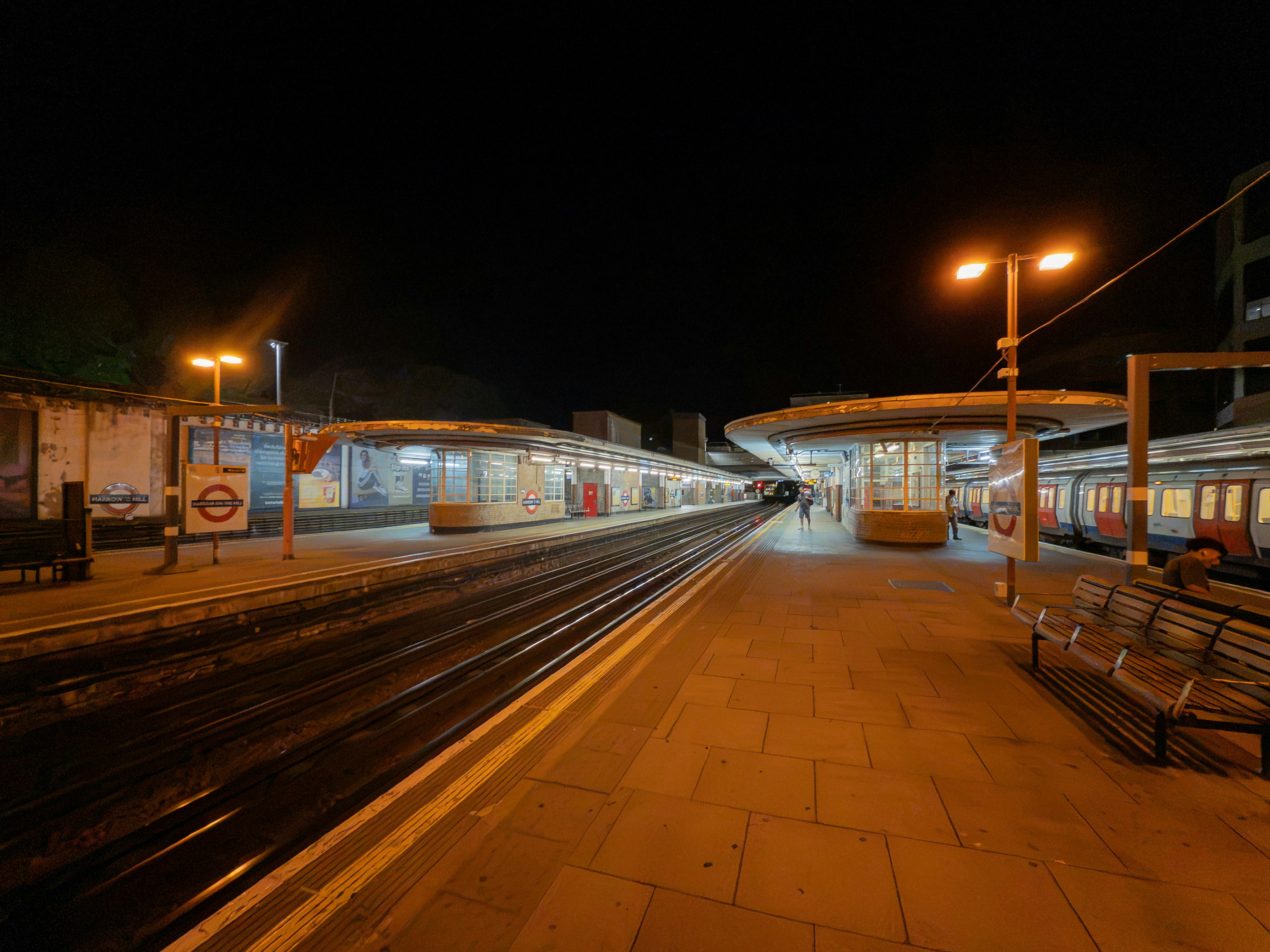 Night Platform Echoes: Trains Rest Under Orange Glow