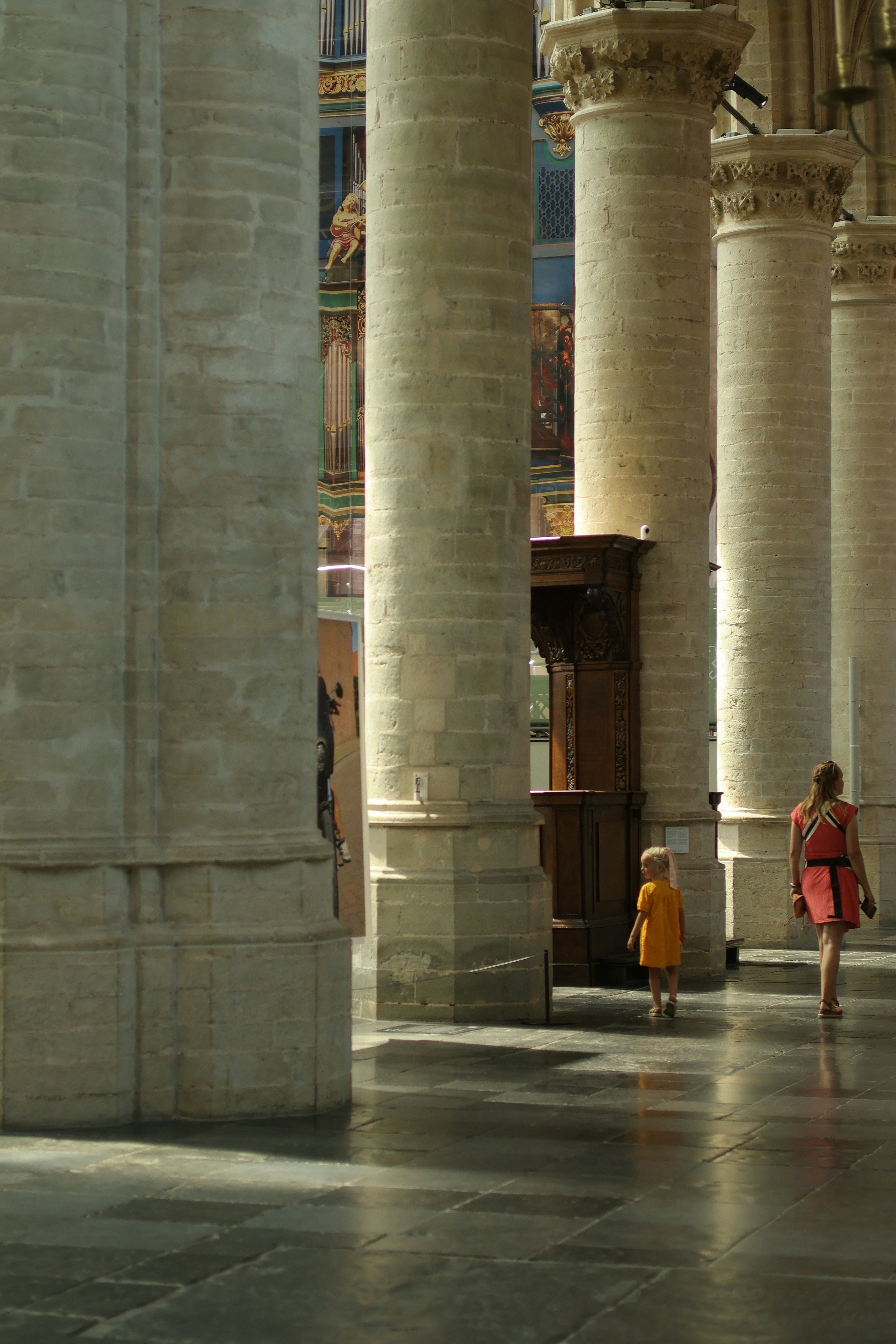 Columns of Silence: A Child and a Woman in a Sunlit Gallery