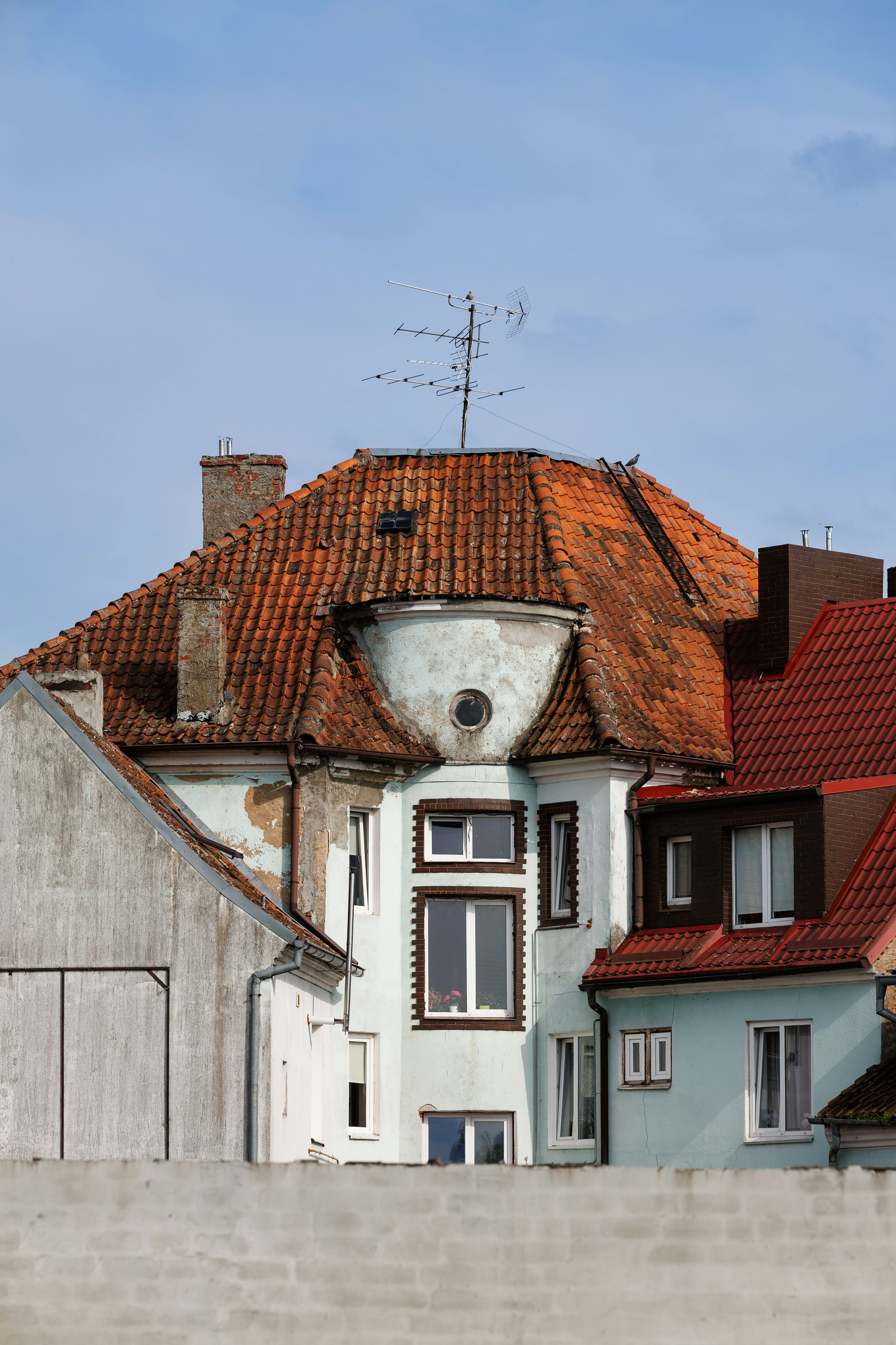 Row of quaint European rooftops under a bright blue sky