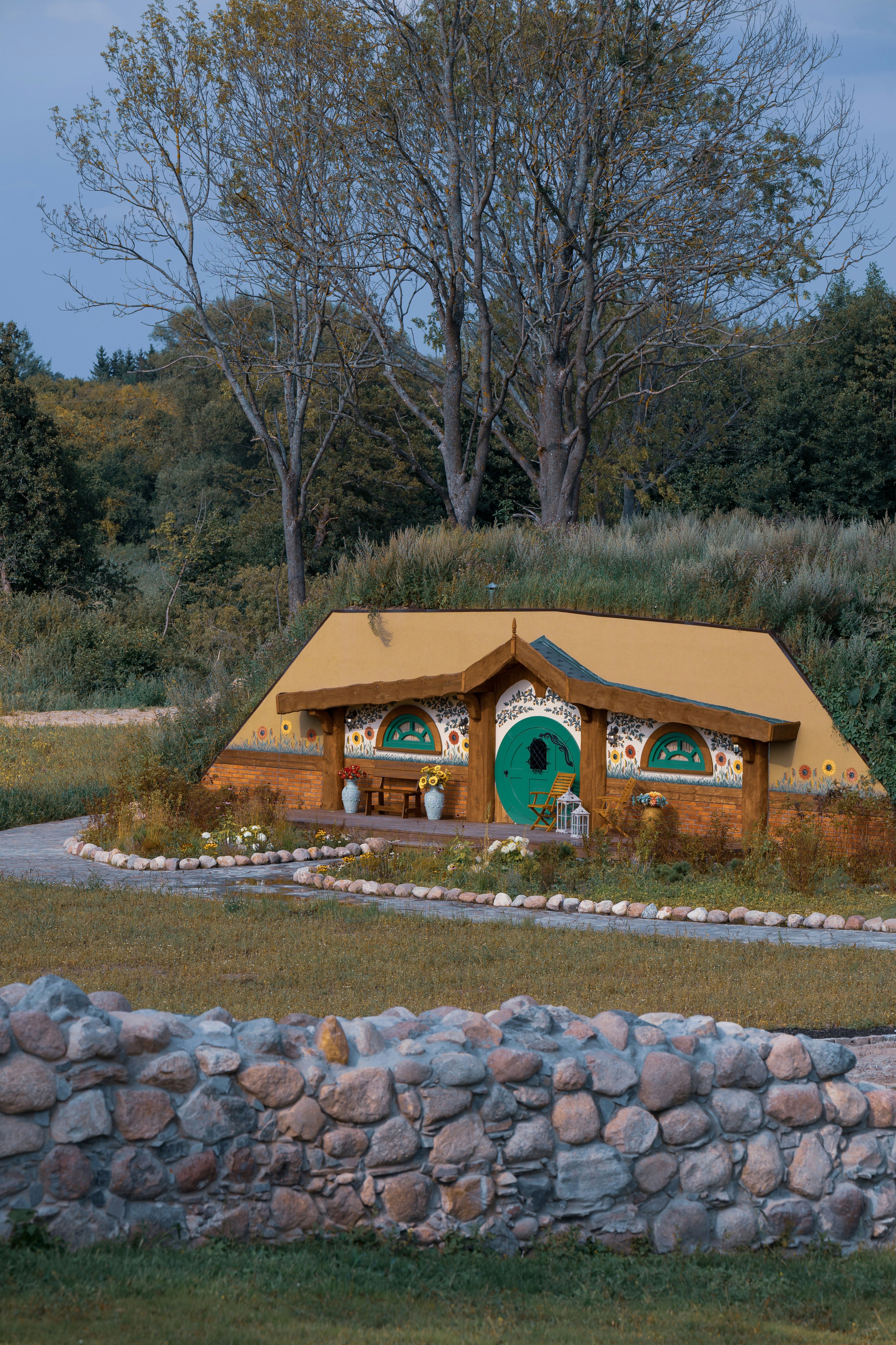 Hearth in the Meadow: a whimsical hobbit-like dwelling amid a tranquil landscape