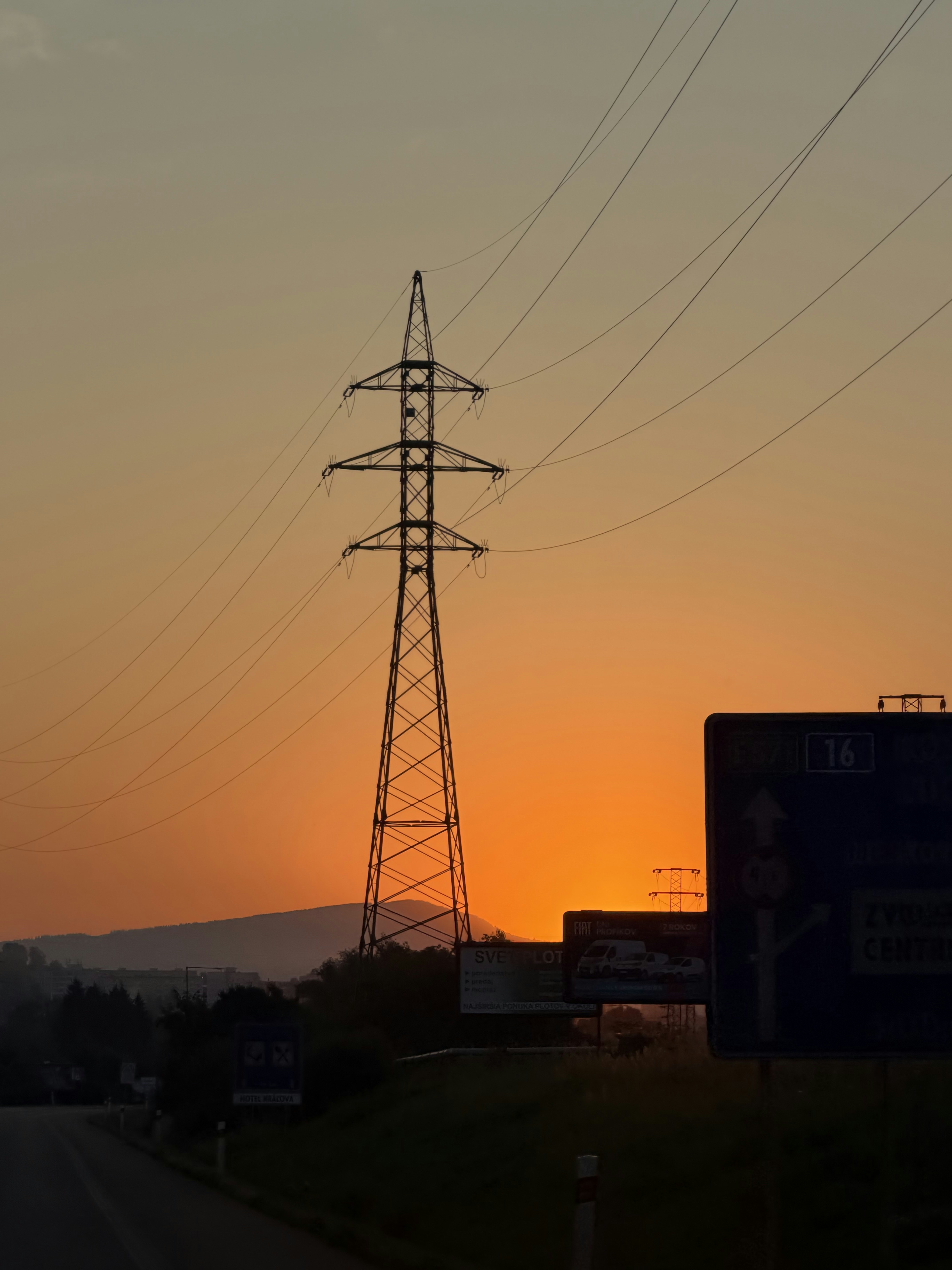 Silhouette Lanterns: Sunset Powerline Symphony on a Quiet Road