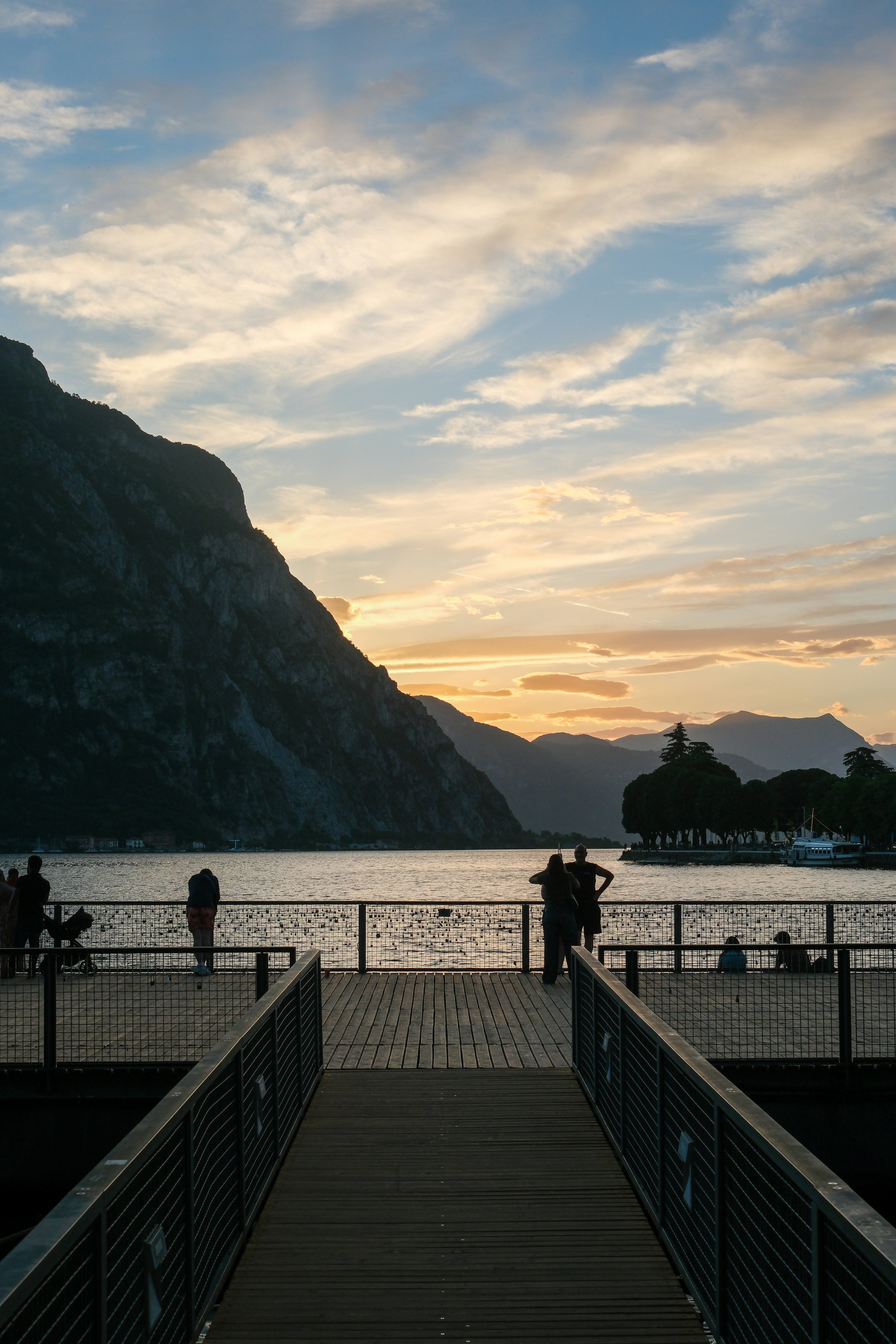 Sunset Pier: silhouettes and calm water beneath a sculpted cliff