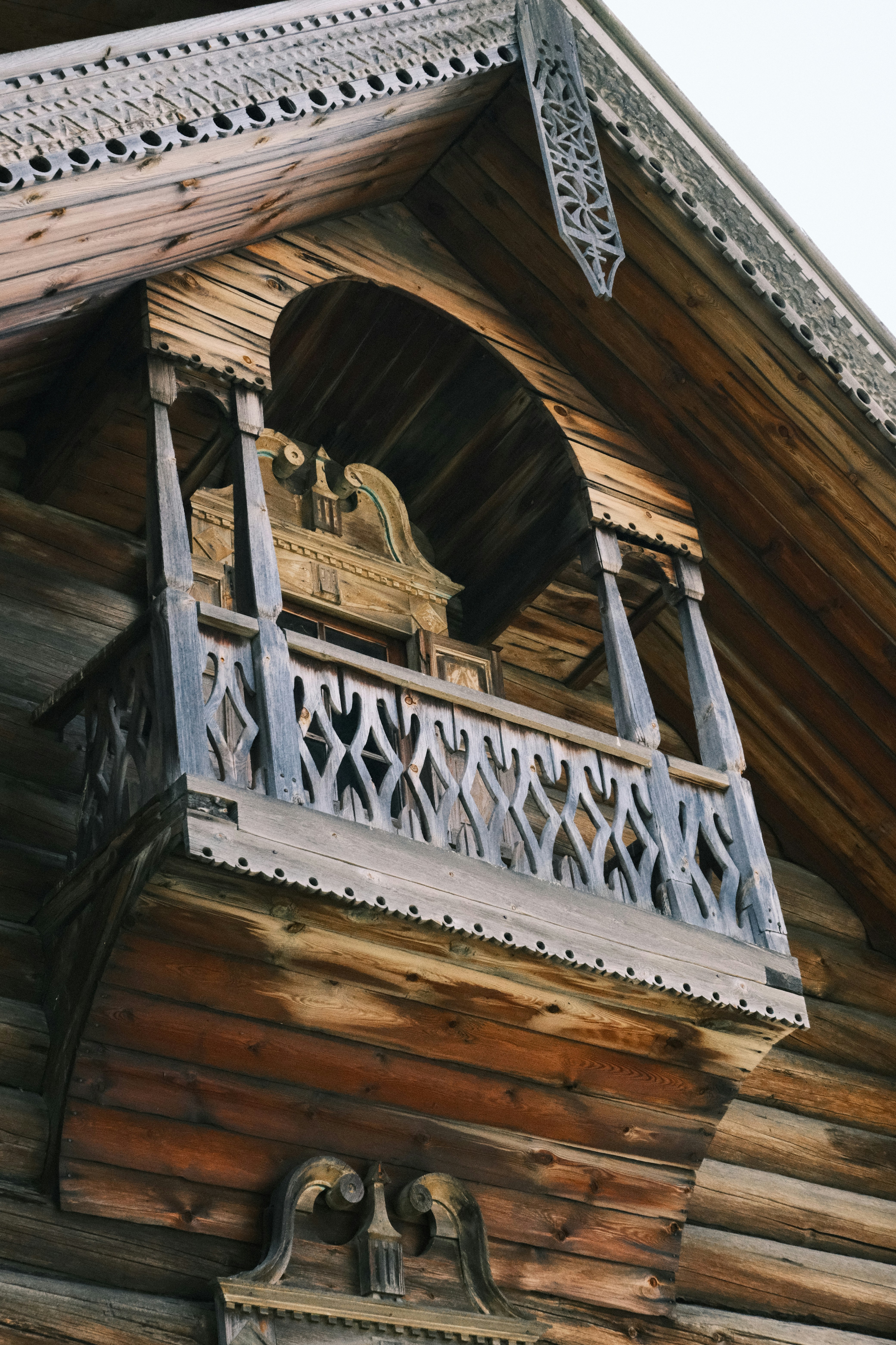 Carved wooden balcony overhang on a rustic log house