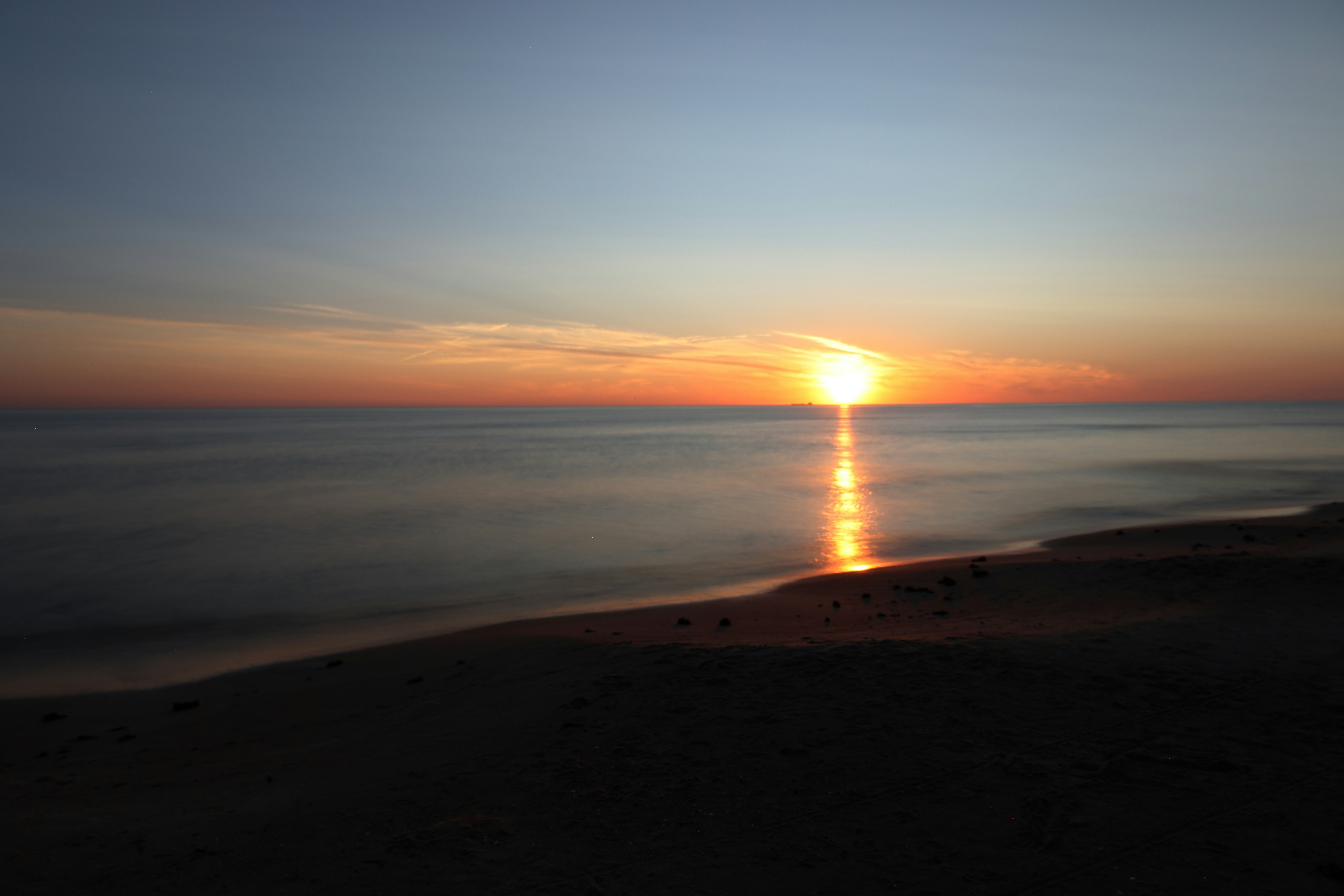 Sunlit Strait: Sunset over a Calm Coastal Evening