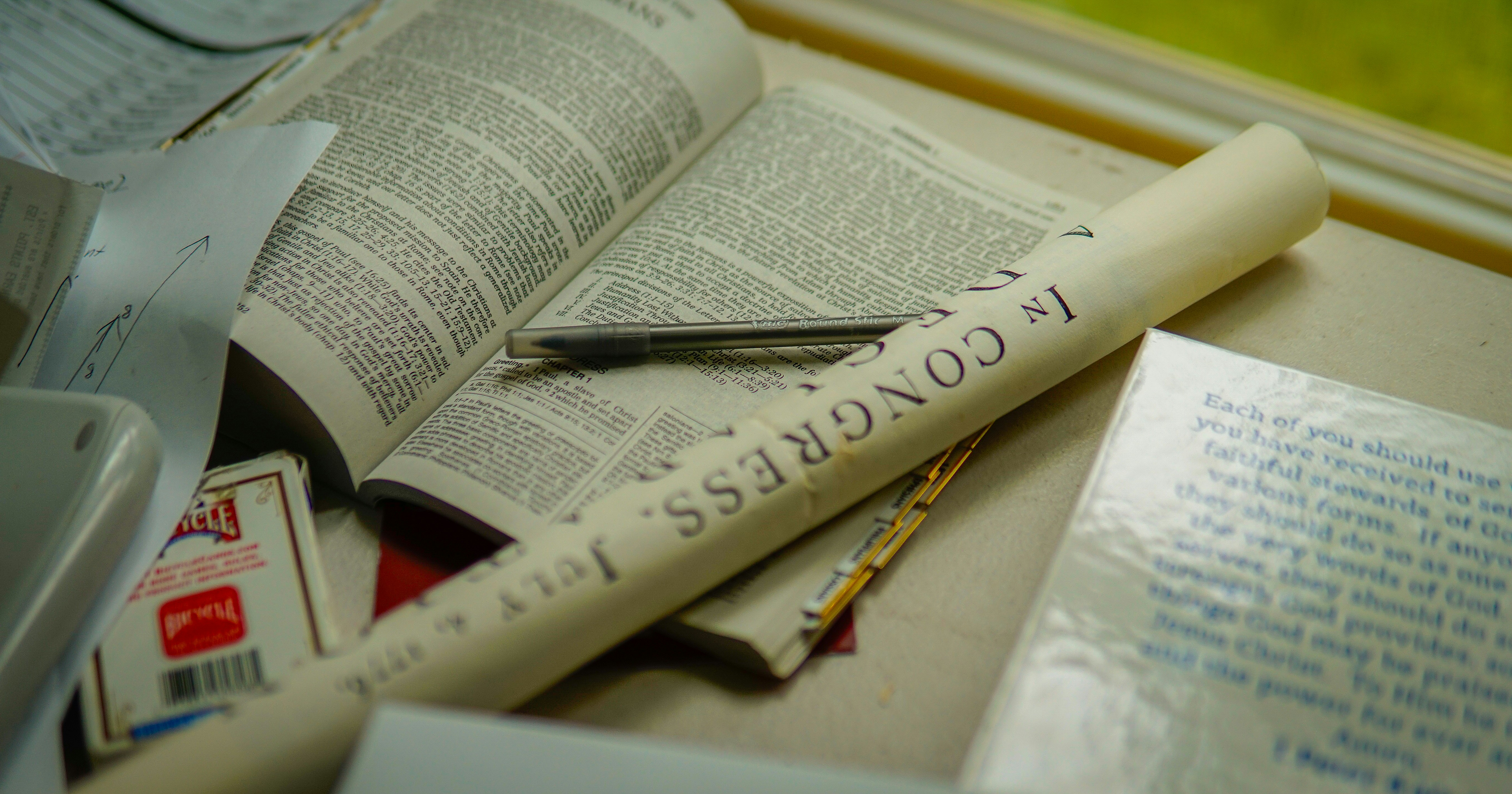 Rolled Manuscript and Open Pages on a Cluttered Desk