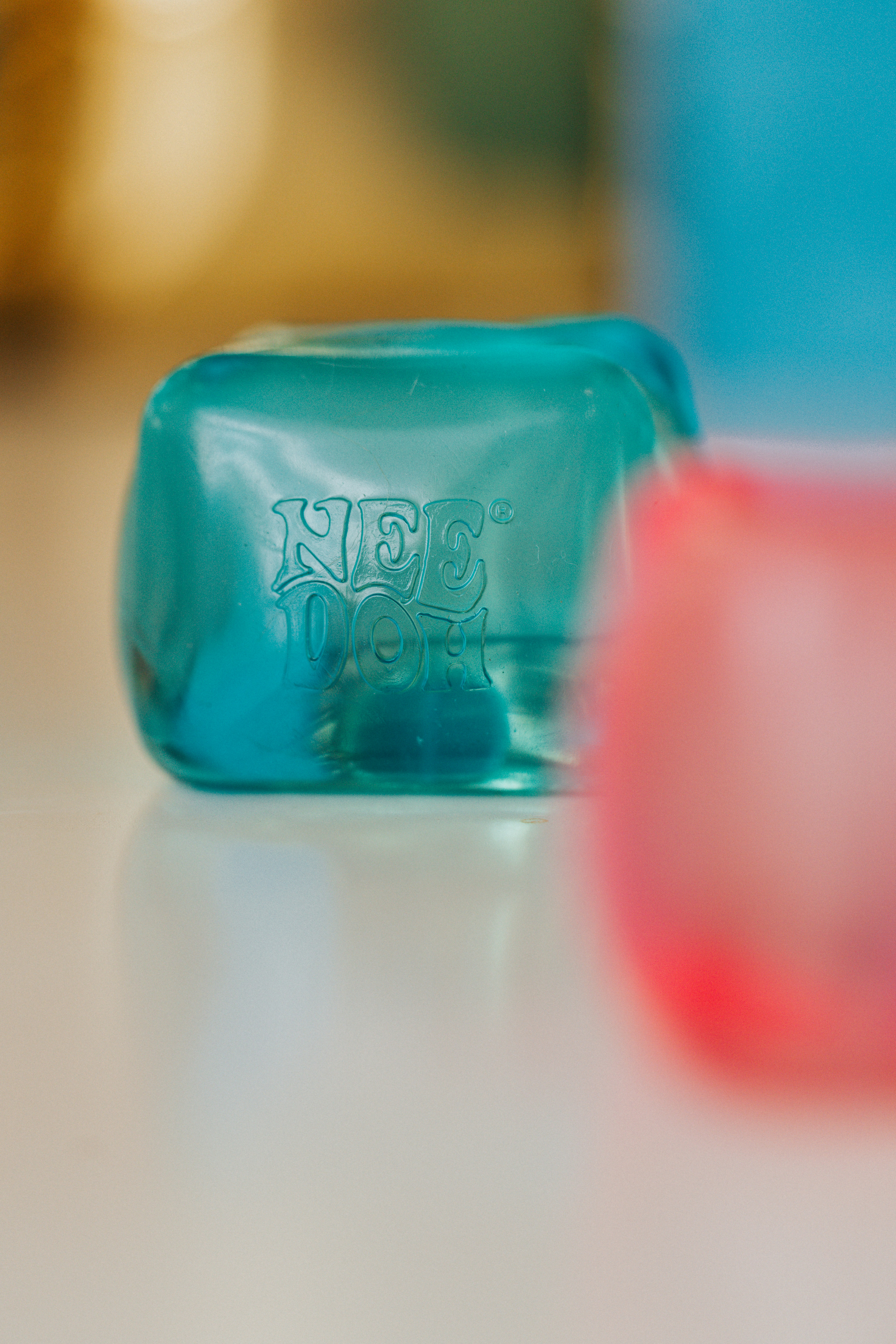 Turquoise Cube in Soft Focus: A Close-Up of Colorful Gels on a Tabletop