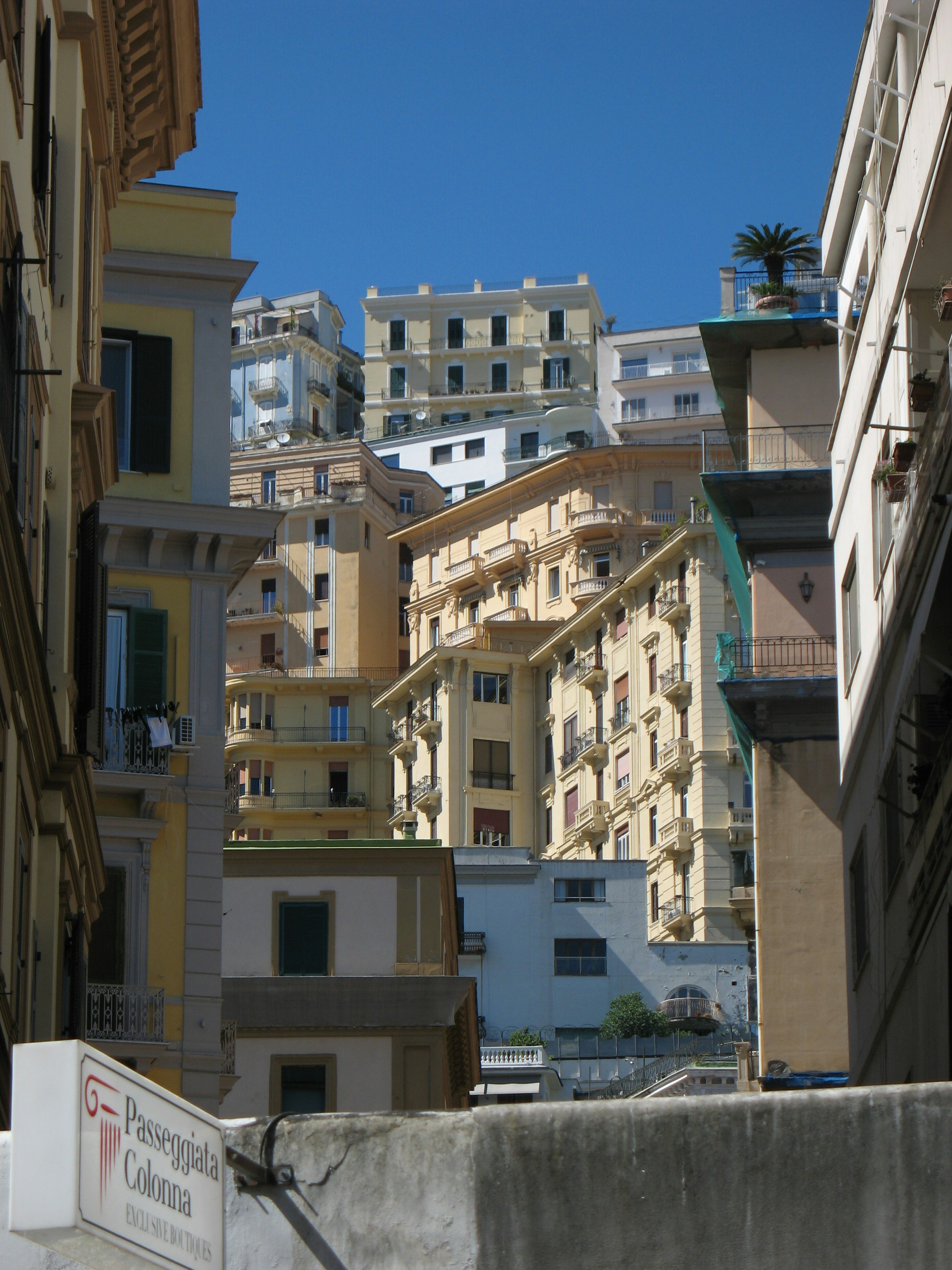 Sunlit Mediterranean Climb: Narrow Street Between Colorful Balconies