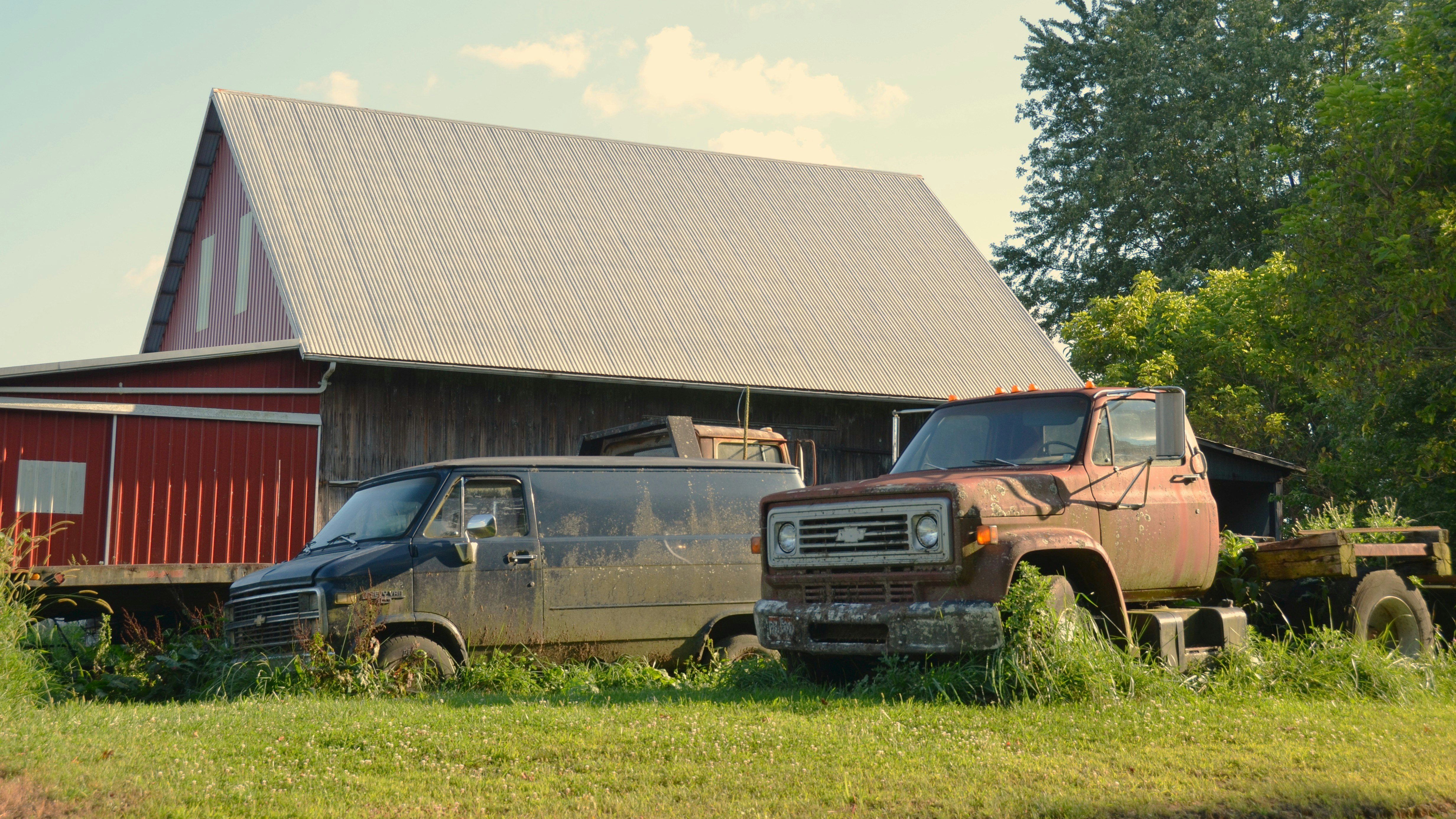 Dusty Farmyard Relics: Abandoned Vehicles by the Barn