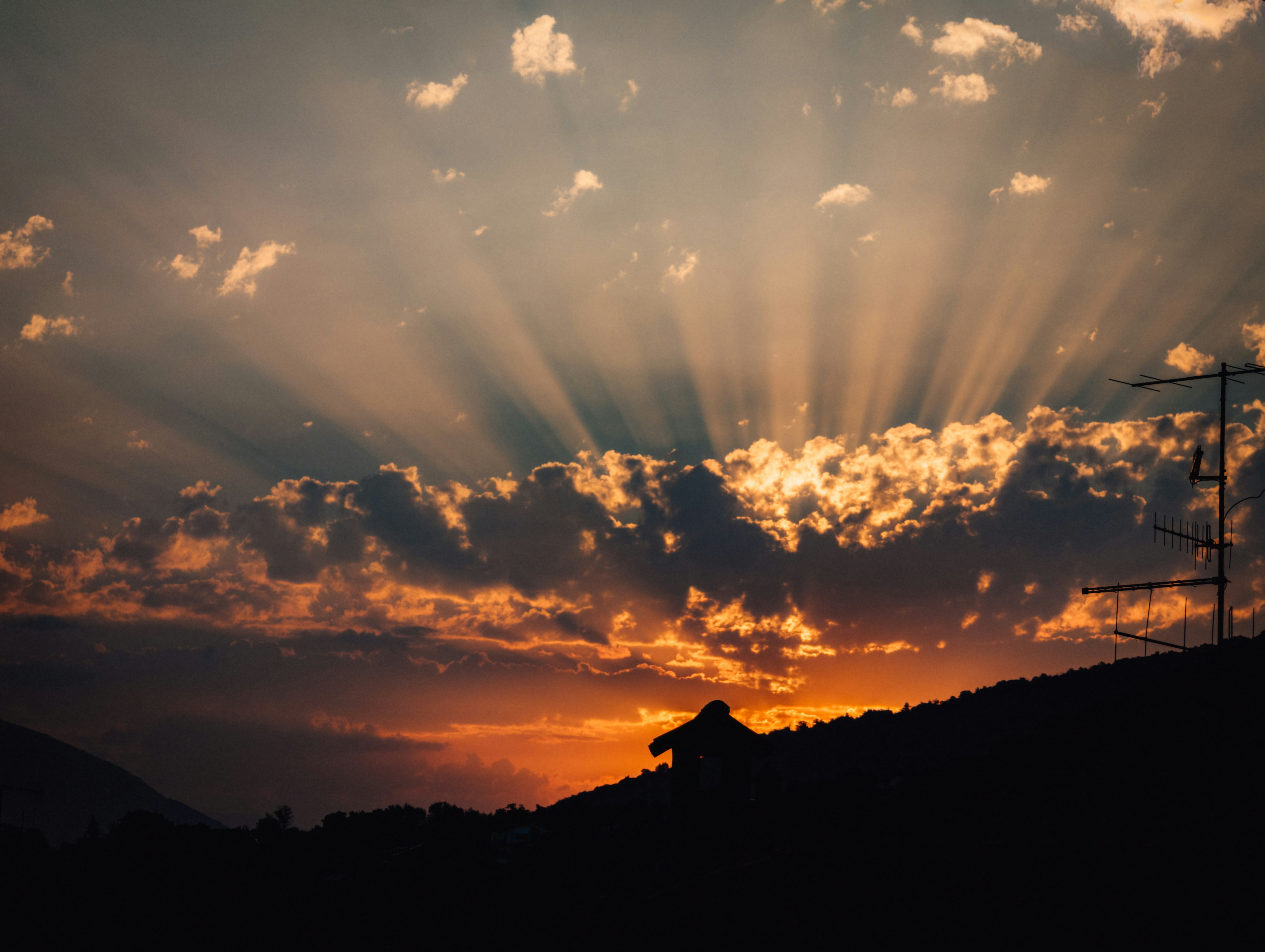 Silhouette at Dusk: Rays Over a Quiet Ridge