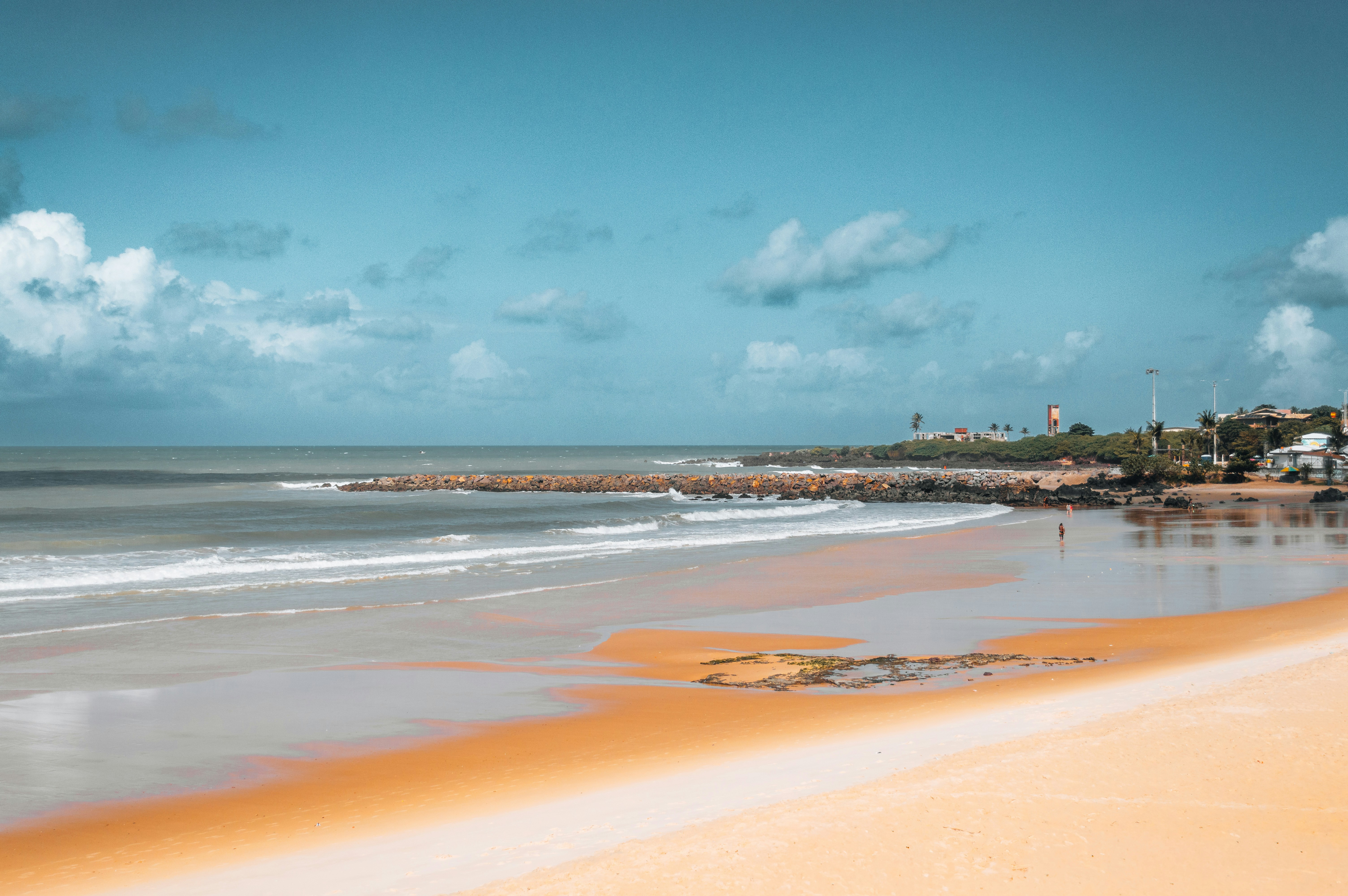 Coastal Horizon: Beach, Tide, and Distant Cliffside Village