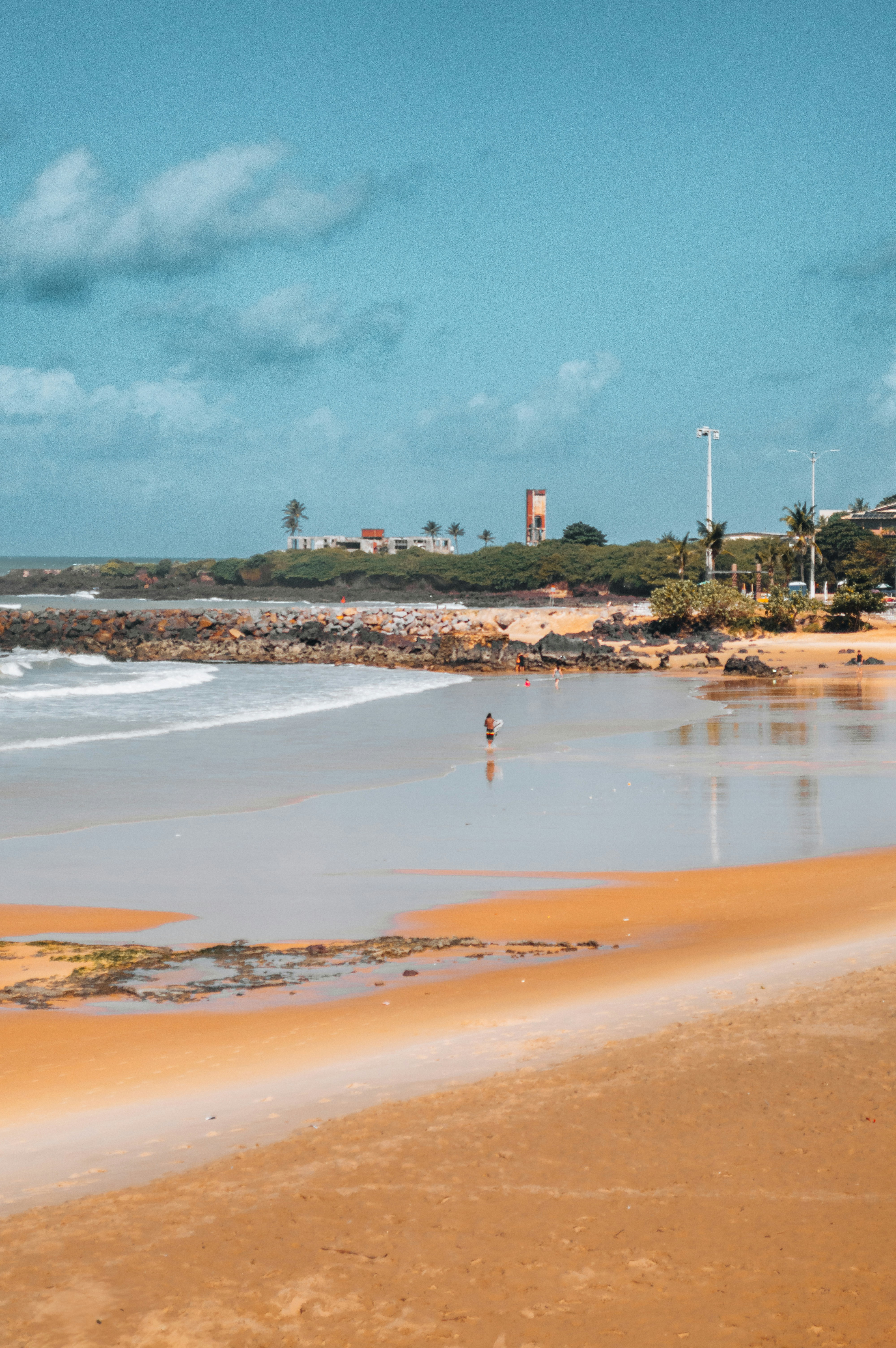 Sunlit Shoreline with Distant Town and Calm Surf